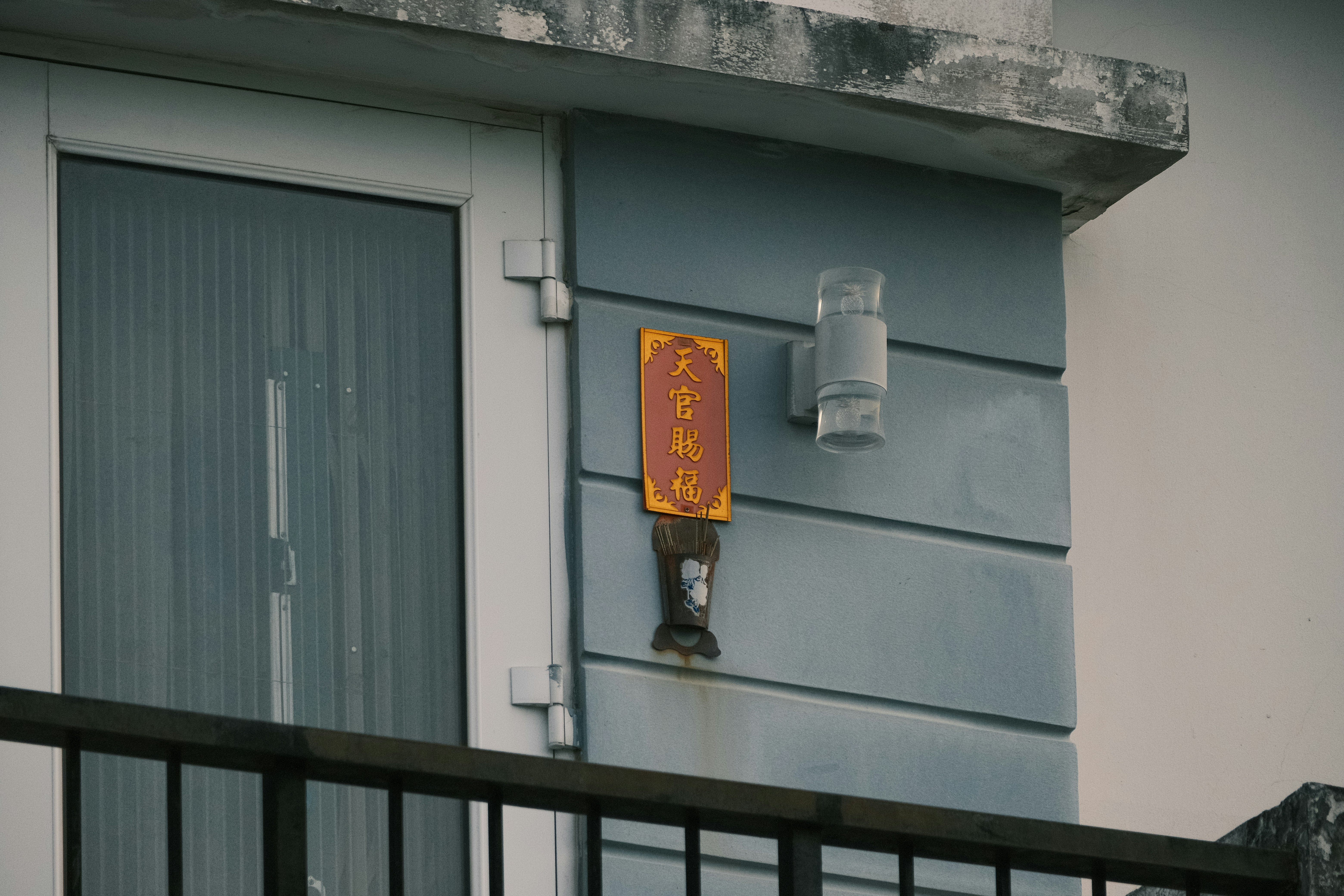 Warning Sign on a Blue Facade Overlooking a Balcony