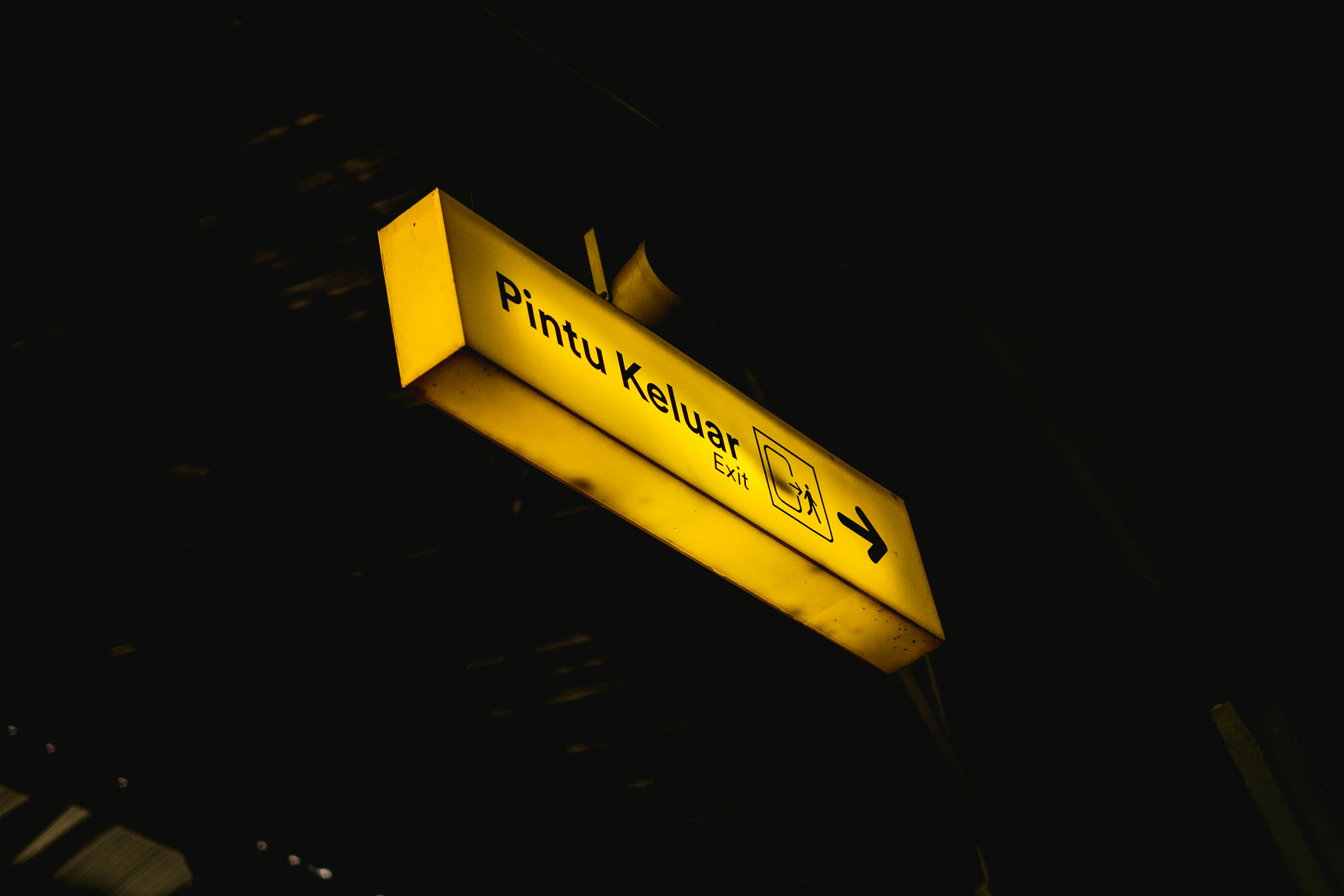 Diagonal Golden Exit Sign Casting a Narrow Path in Night