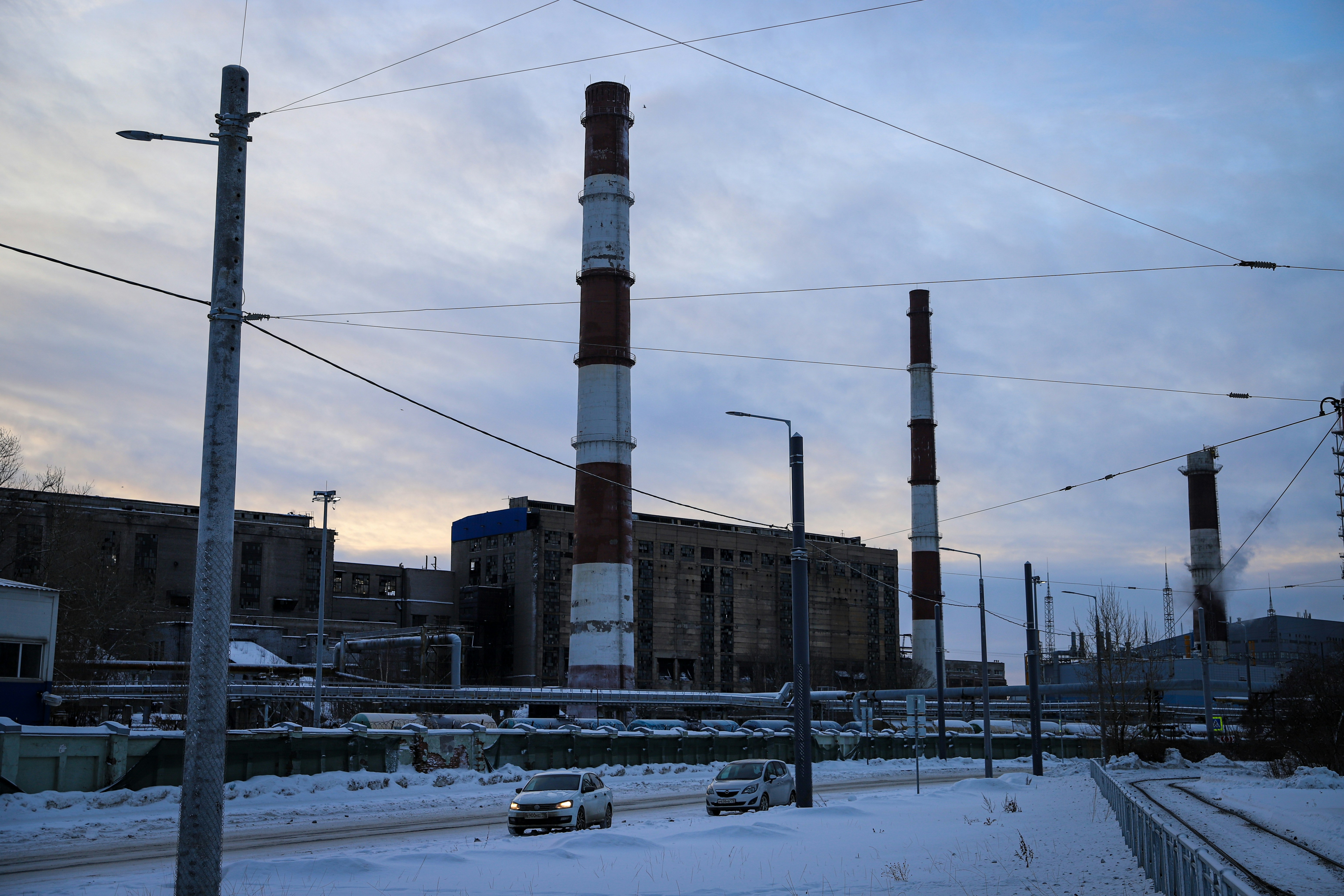 Blue Hour Over Snow: Striped Chimneys Guard the Industrial Park