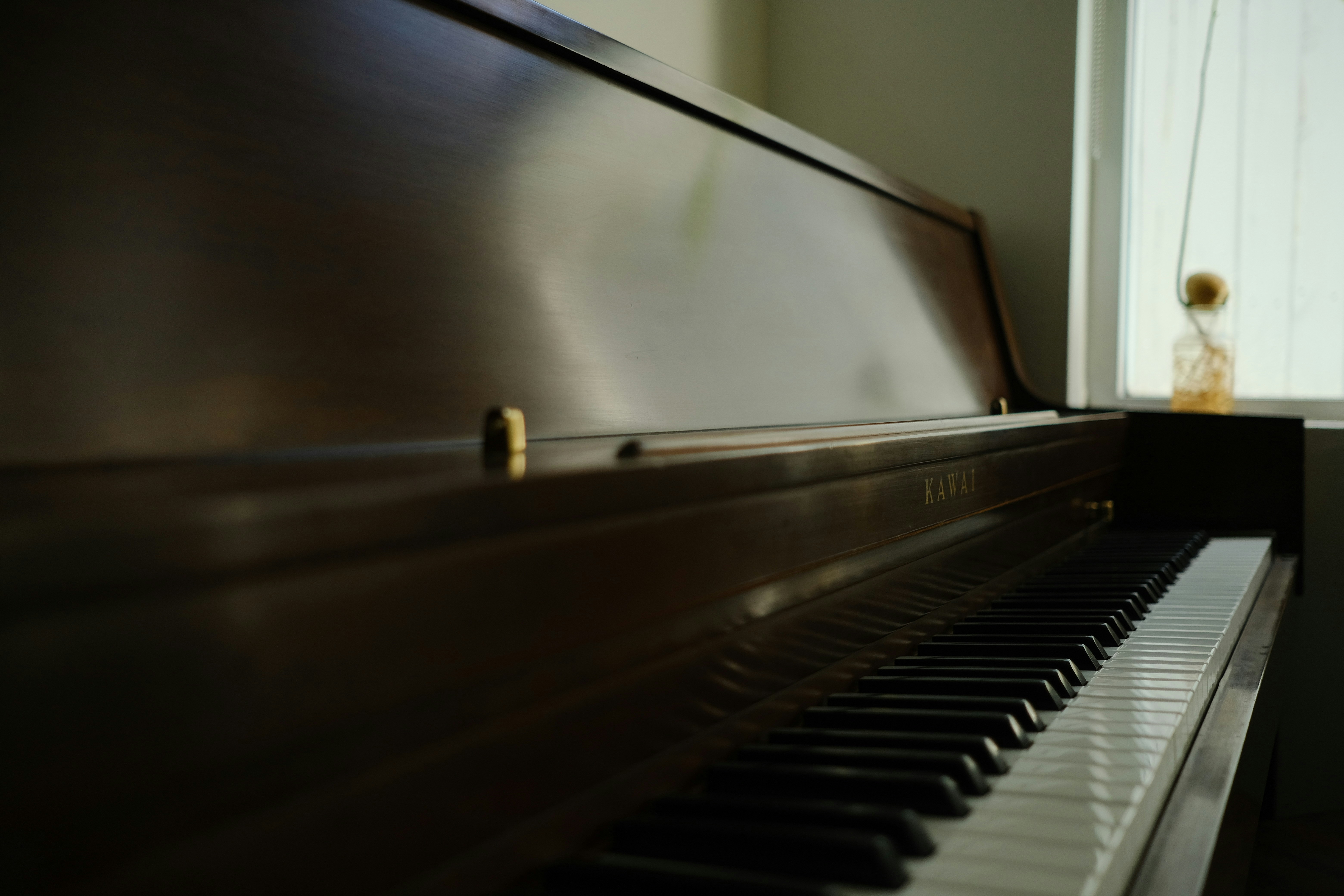 Close-up of a piano keyboard with soft light streaming through a nearby window.