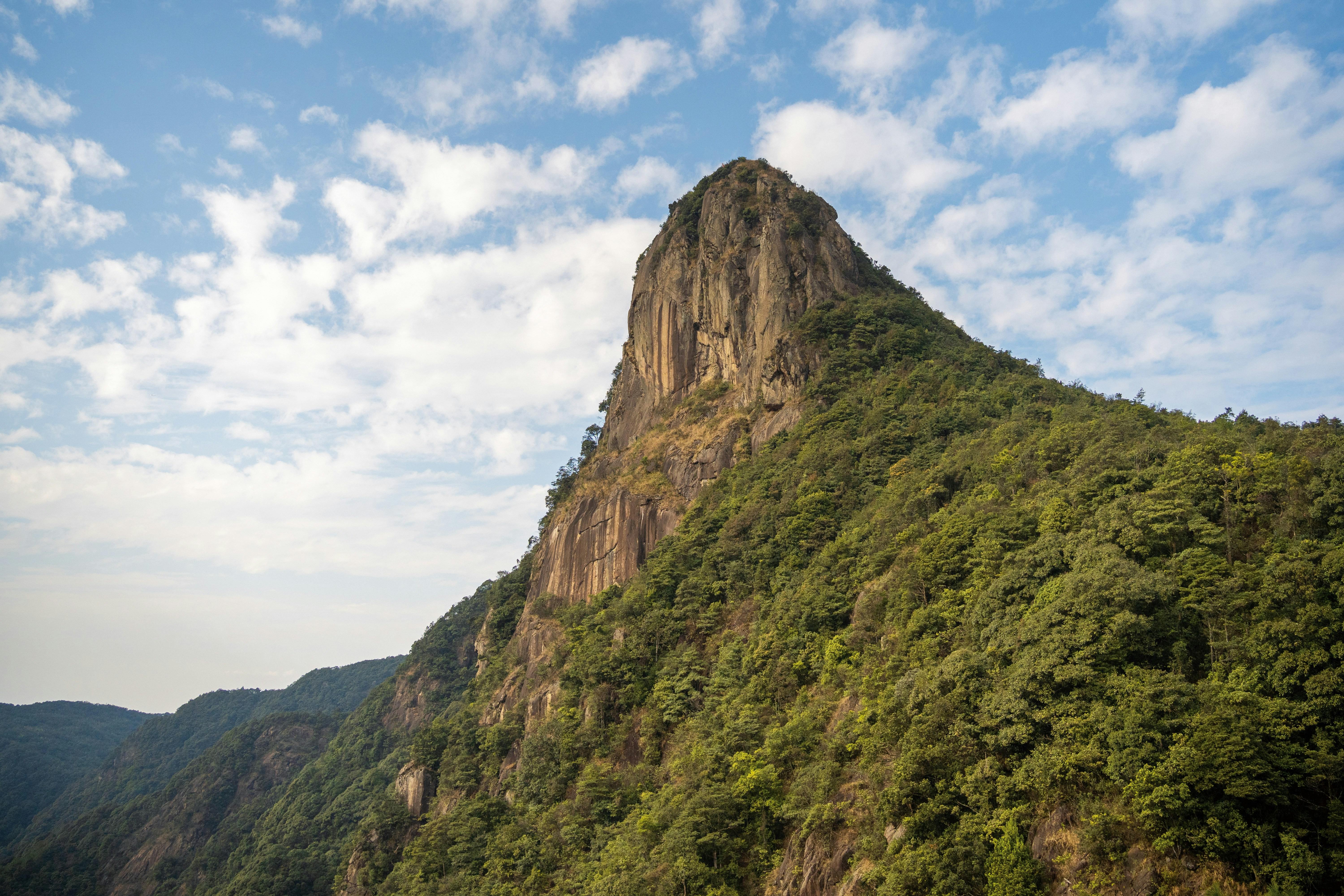 A large mountain with trees on the side of it photo – Free Jizhen ...