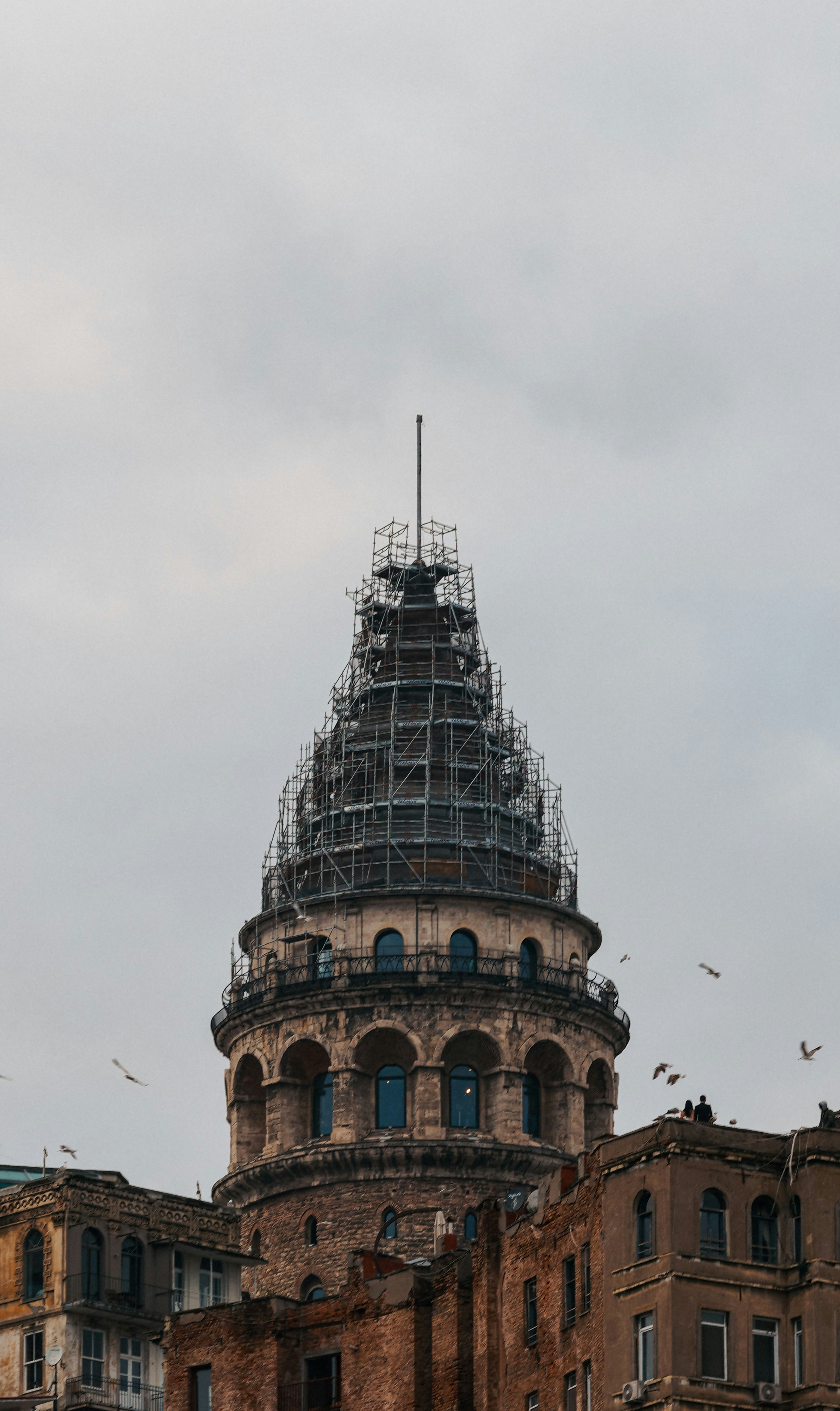 Stone Tower Crowned in Scaffolding Rises Above City Rooftops