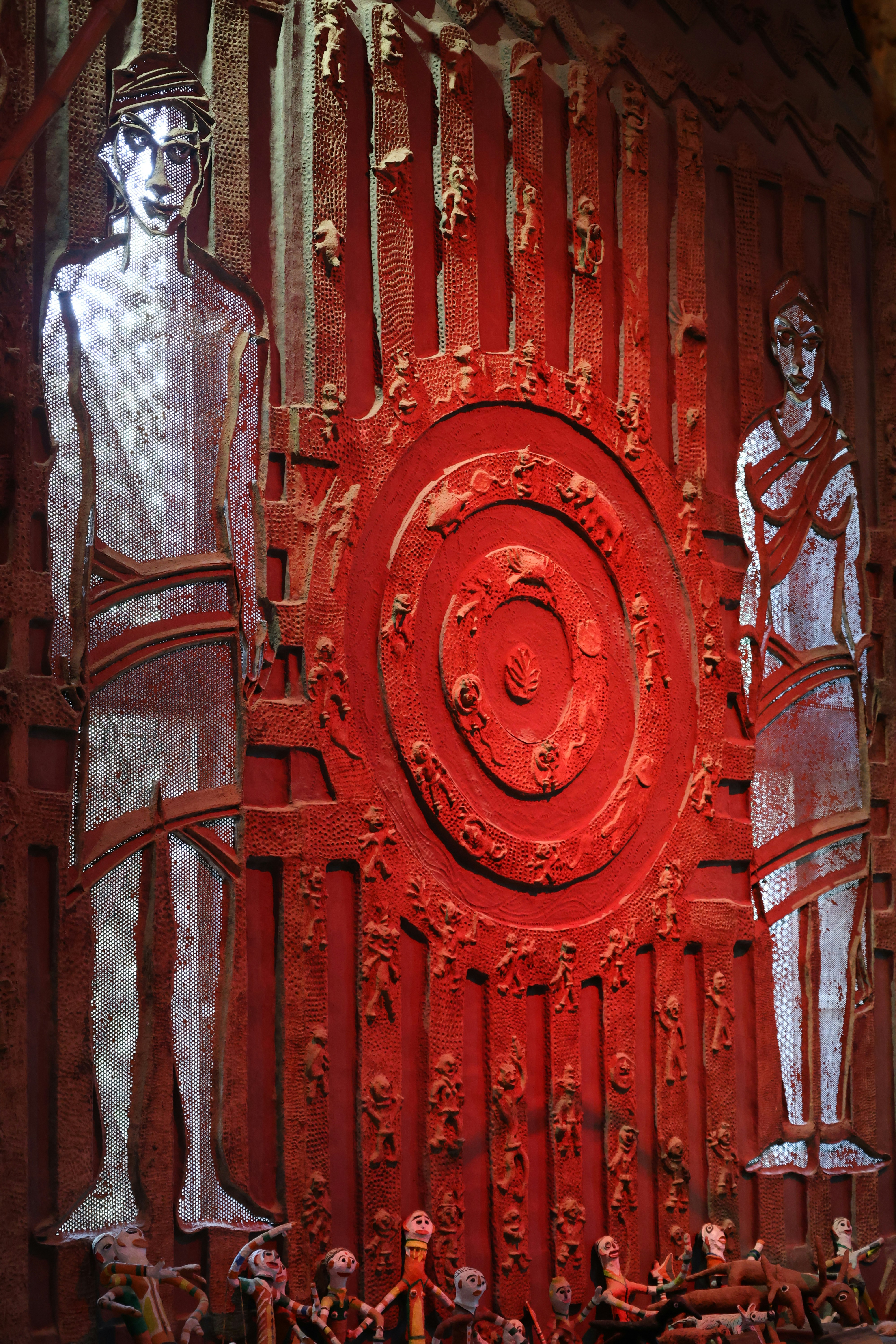 Crimson Gatekeepers: A Circular Core Framed by Pale Statues
