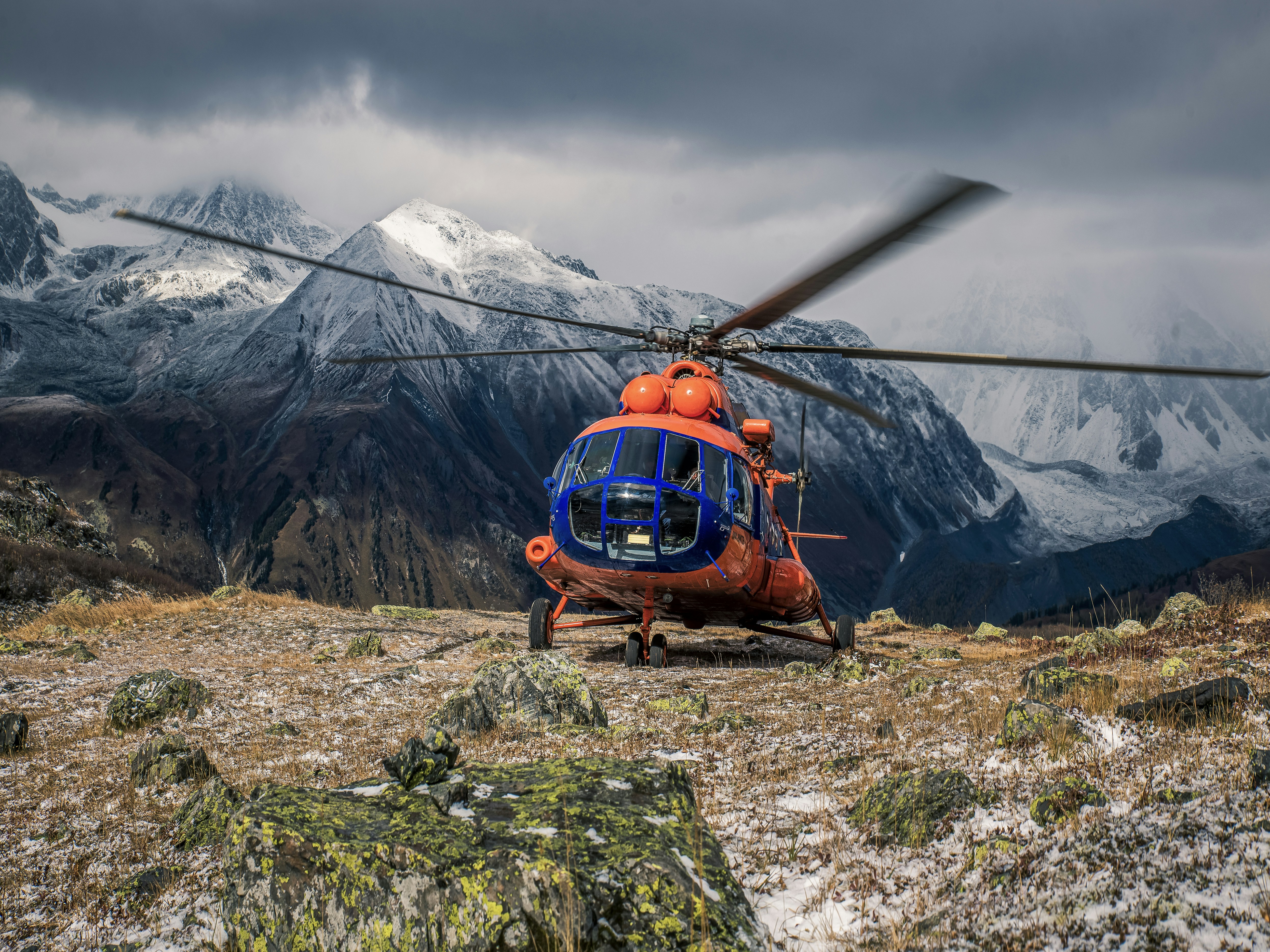 Crimson Rescue Helicopter Against a Snowbound Alpine Ridge