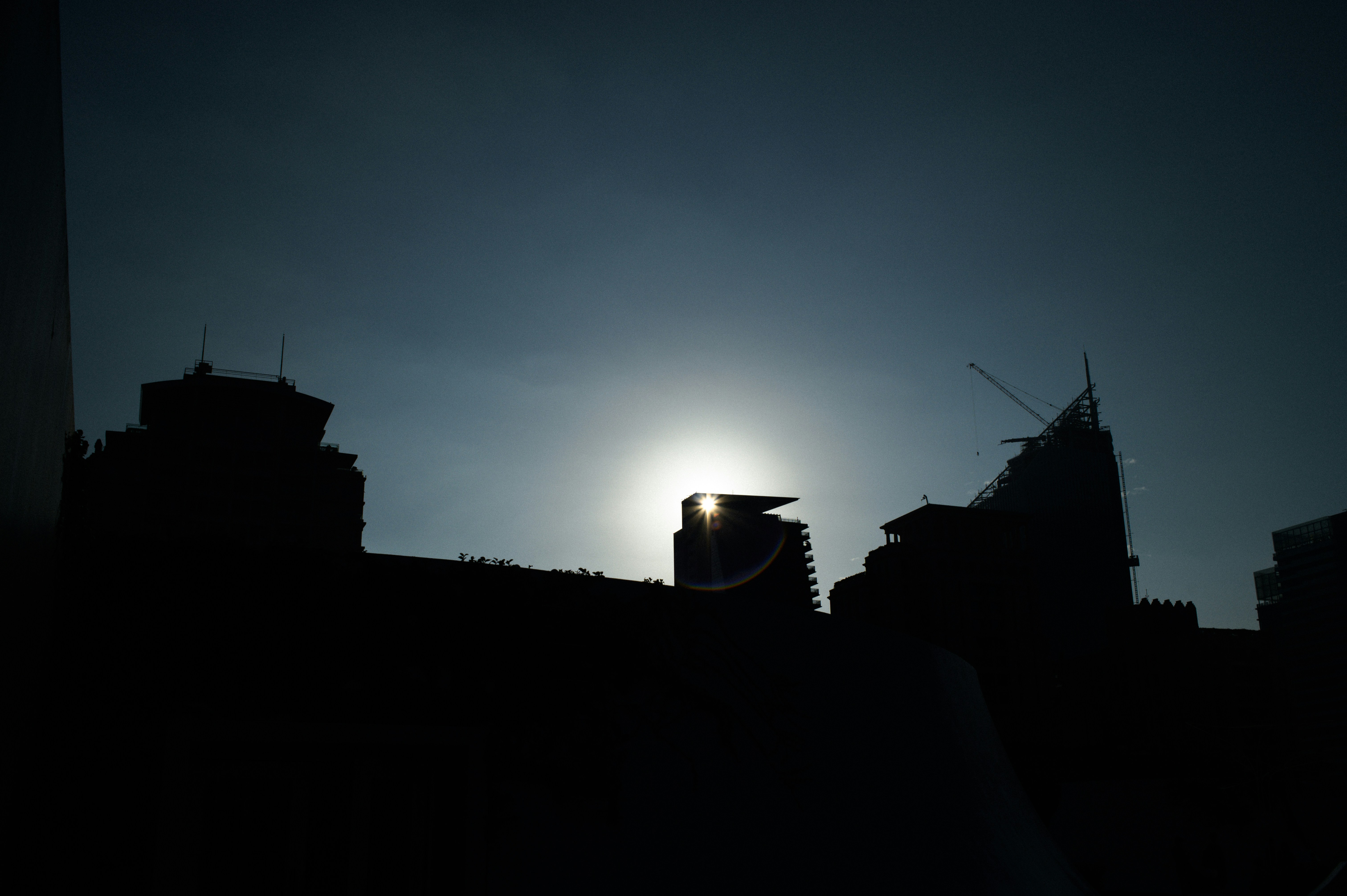 Sun Between Silhouettes: Dusk Over a Quiet City Skyline