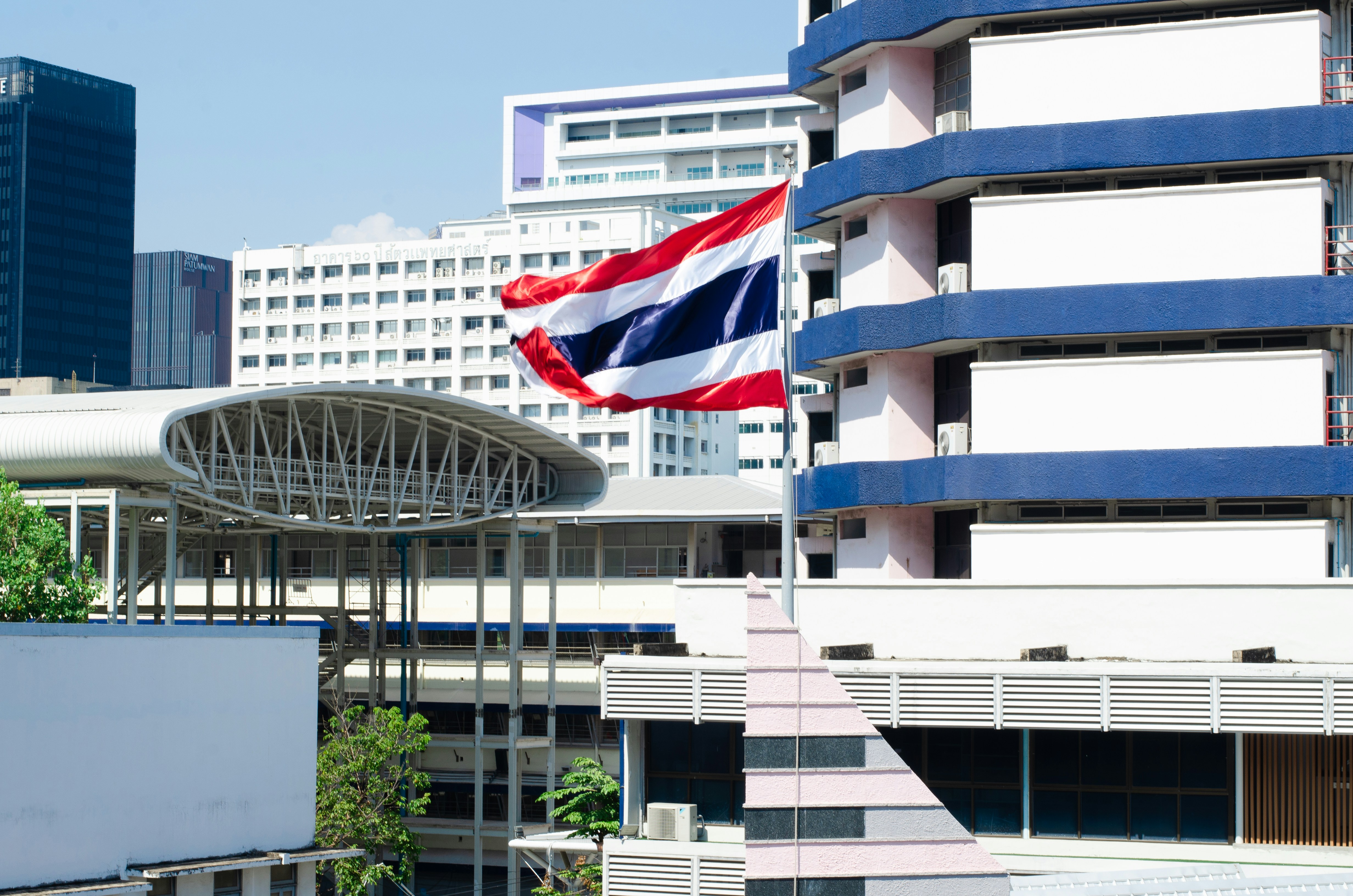 A flag flying in the wind in front of a building photo – Free Building ...