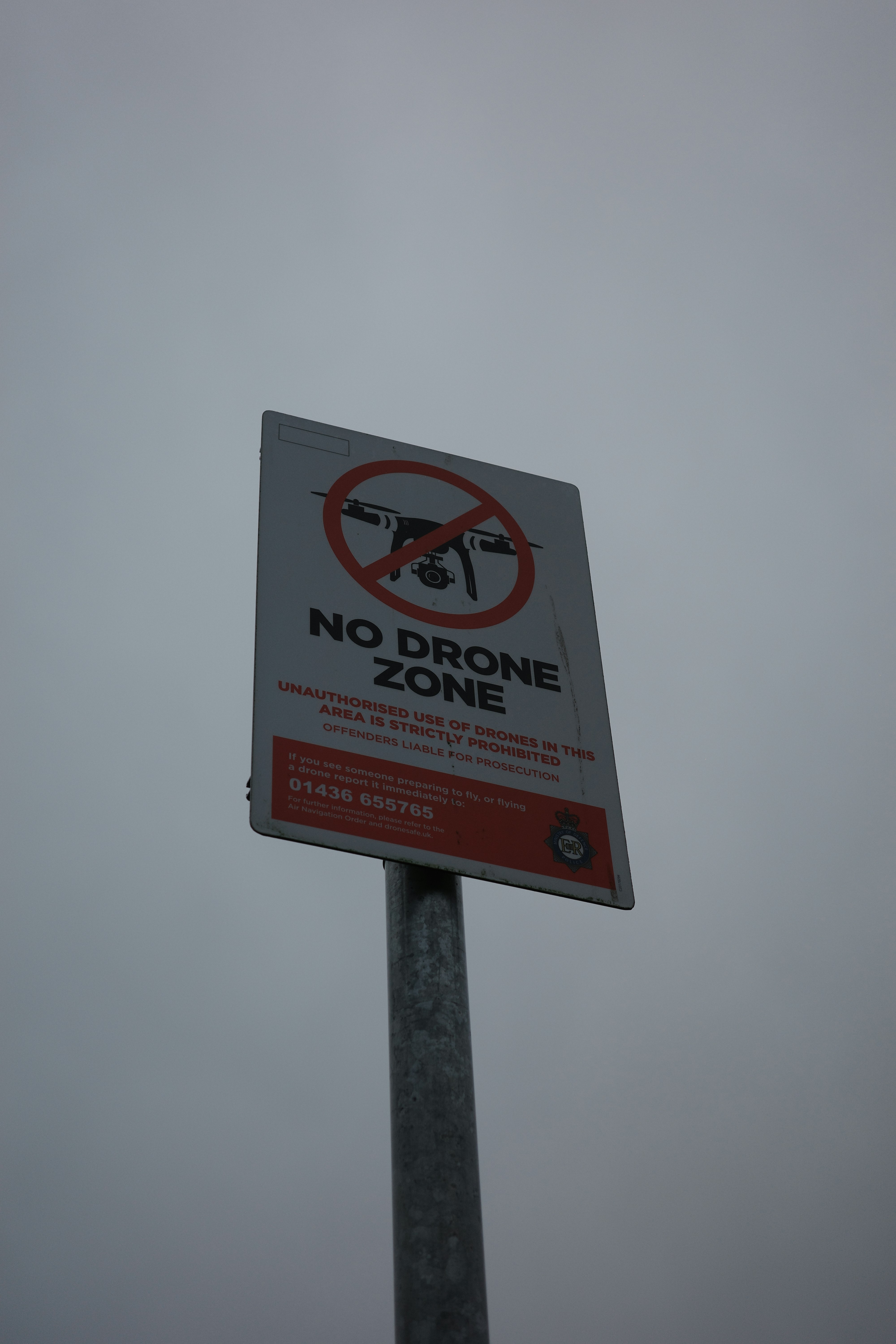 No Drone Zone Sign Angled Against a Gray Sky