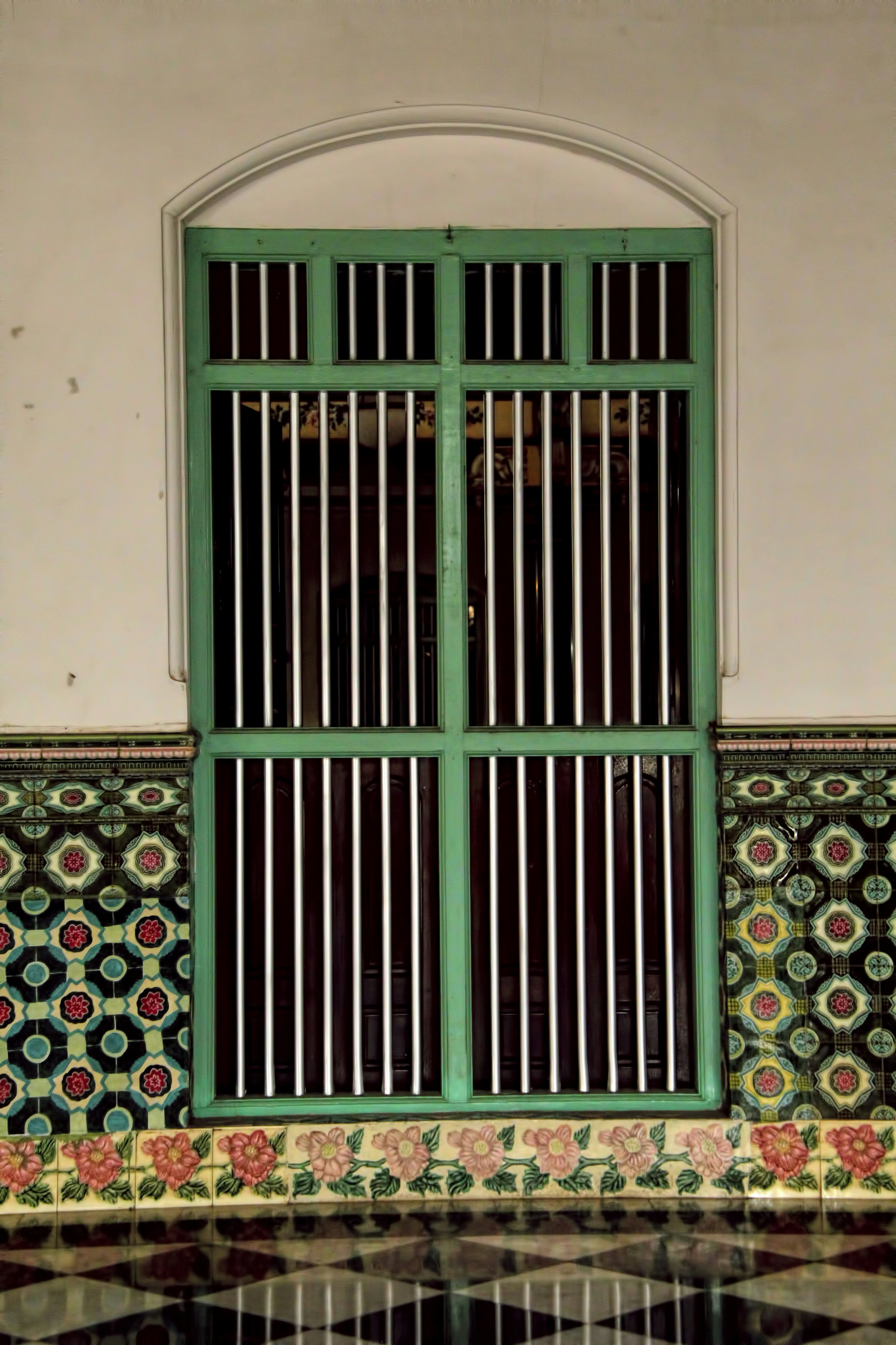 Green Grille Window: A Framed Moment Amid Mosaic Tiles