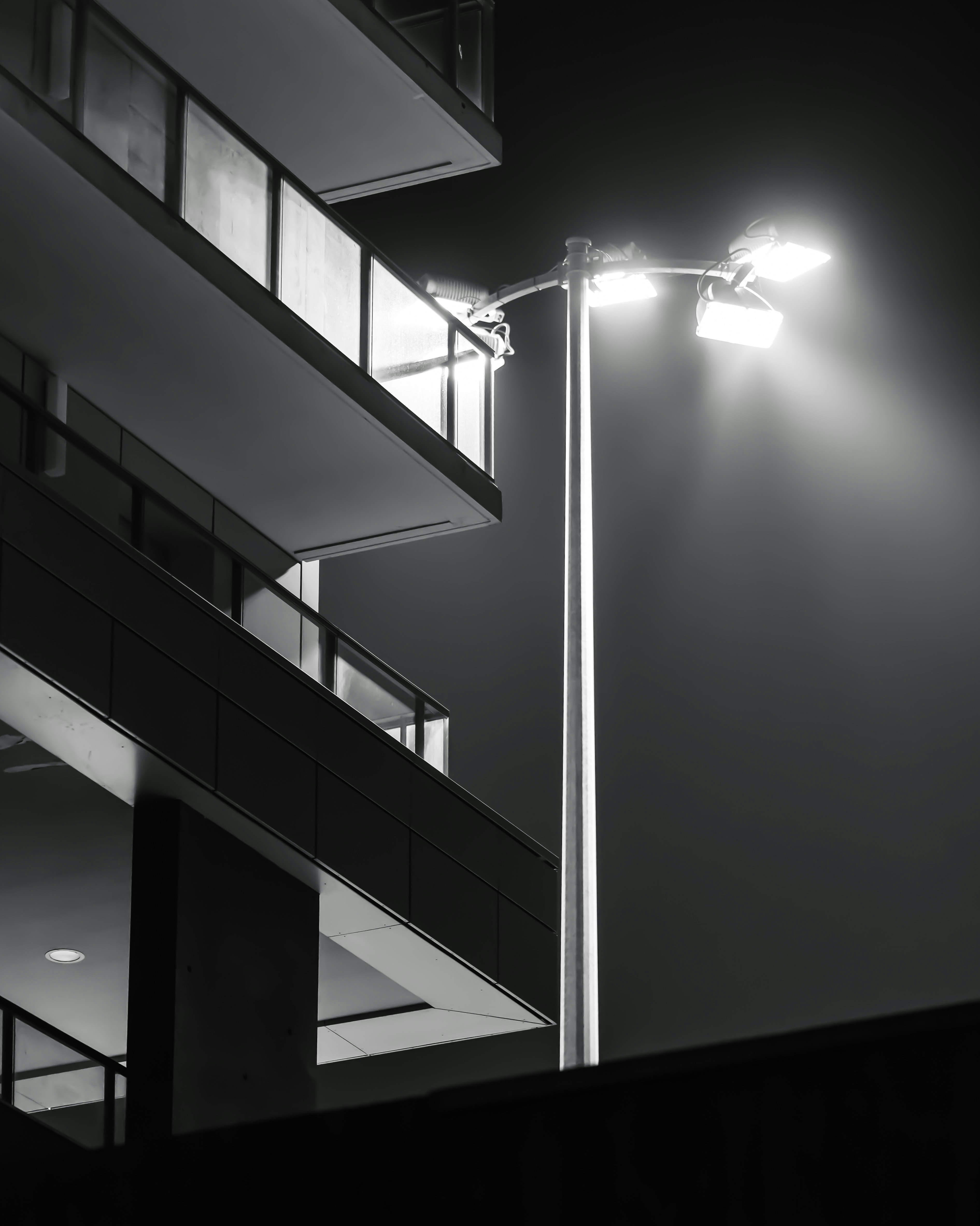 Halo by the Geometric Block: Night Floodlights Beside a Modern Apartment Facade
