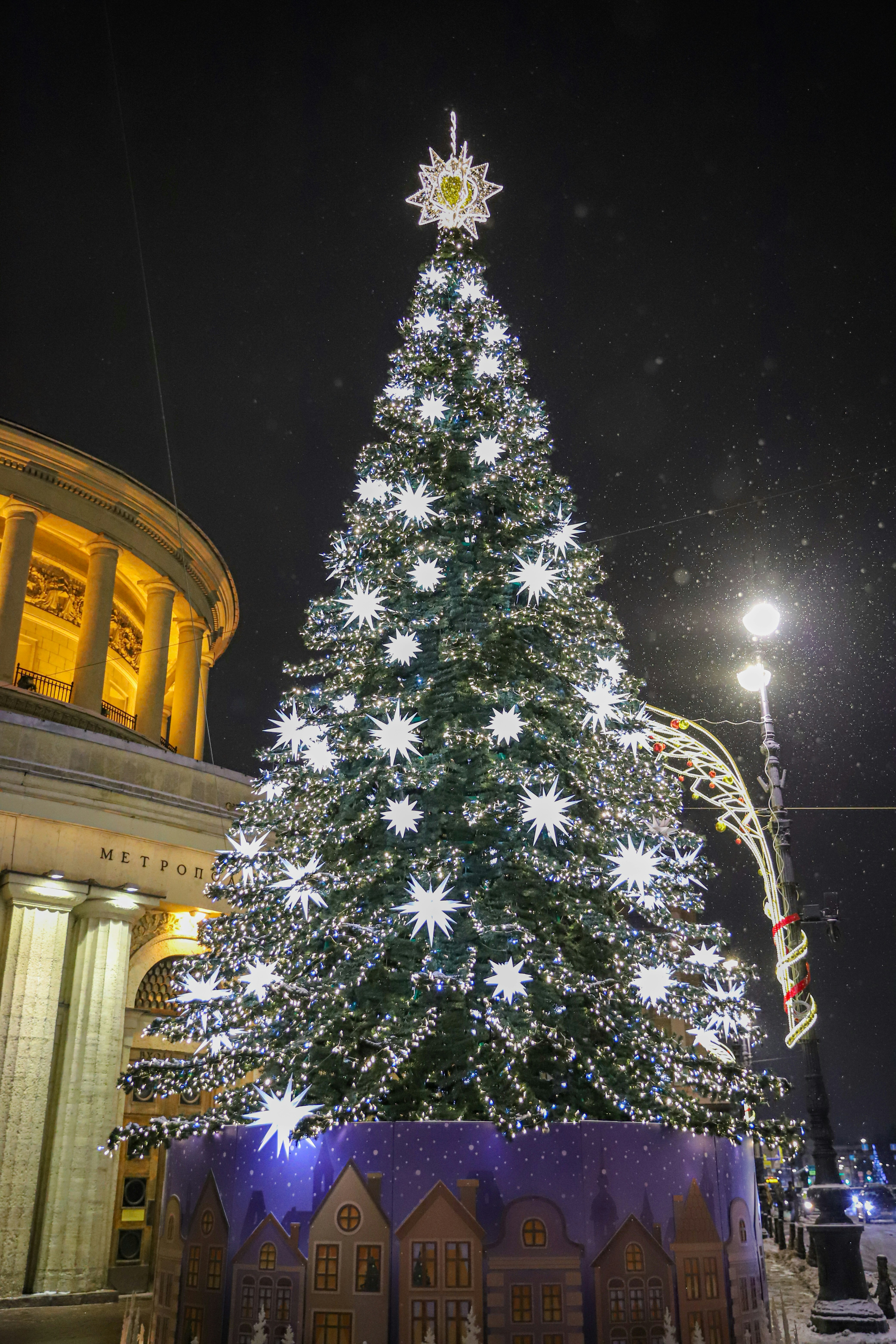 A large christmas tree in front of a building photo – Free Night Image ...