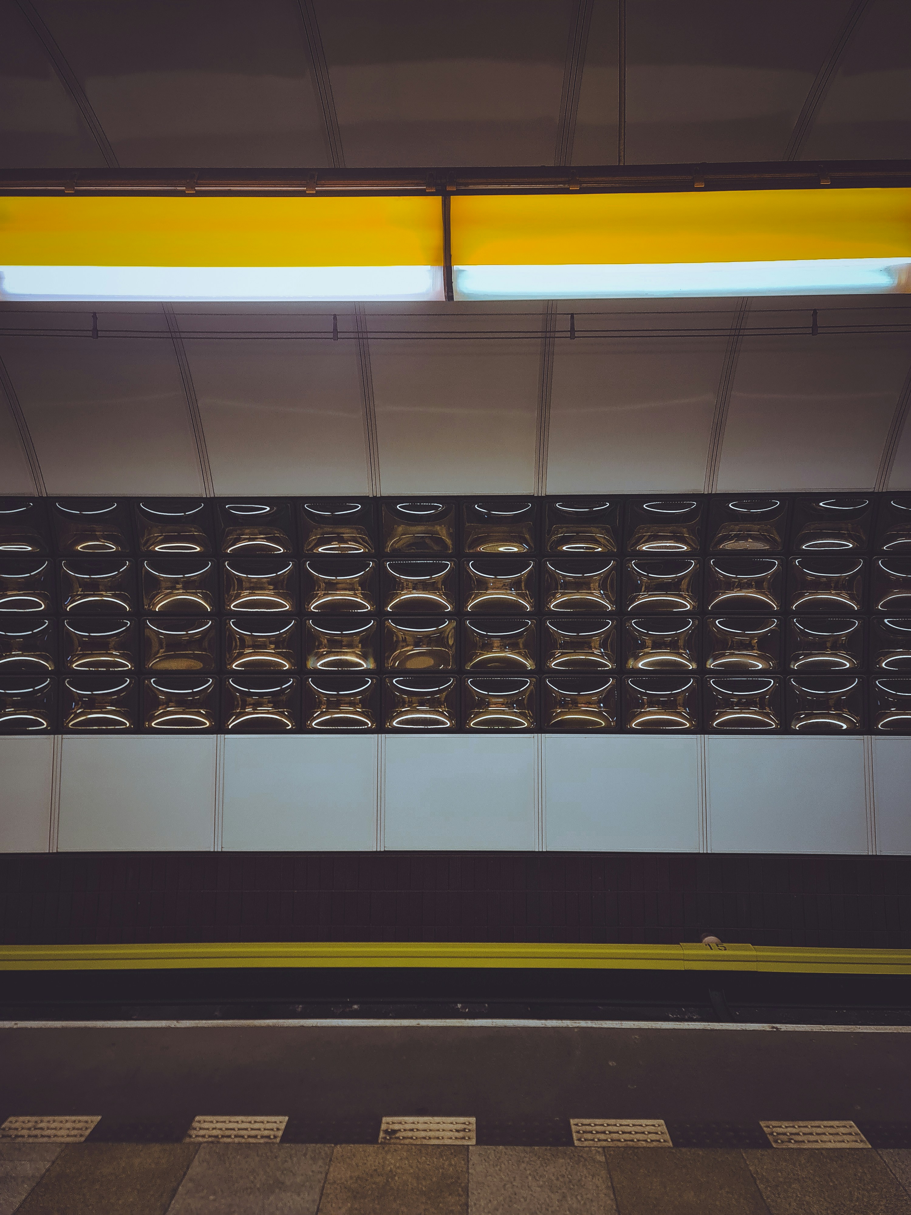 Glass-block Mosaic on a Quiet Subway Platform Under Fluorescent Glow