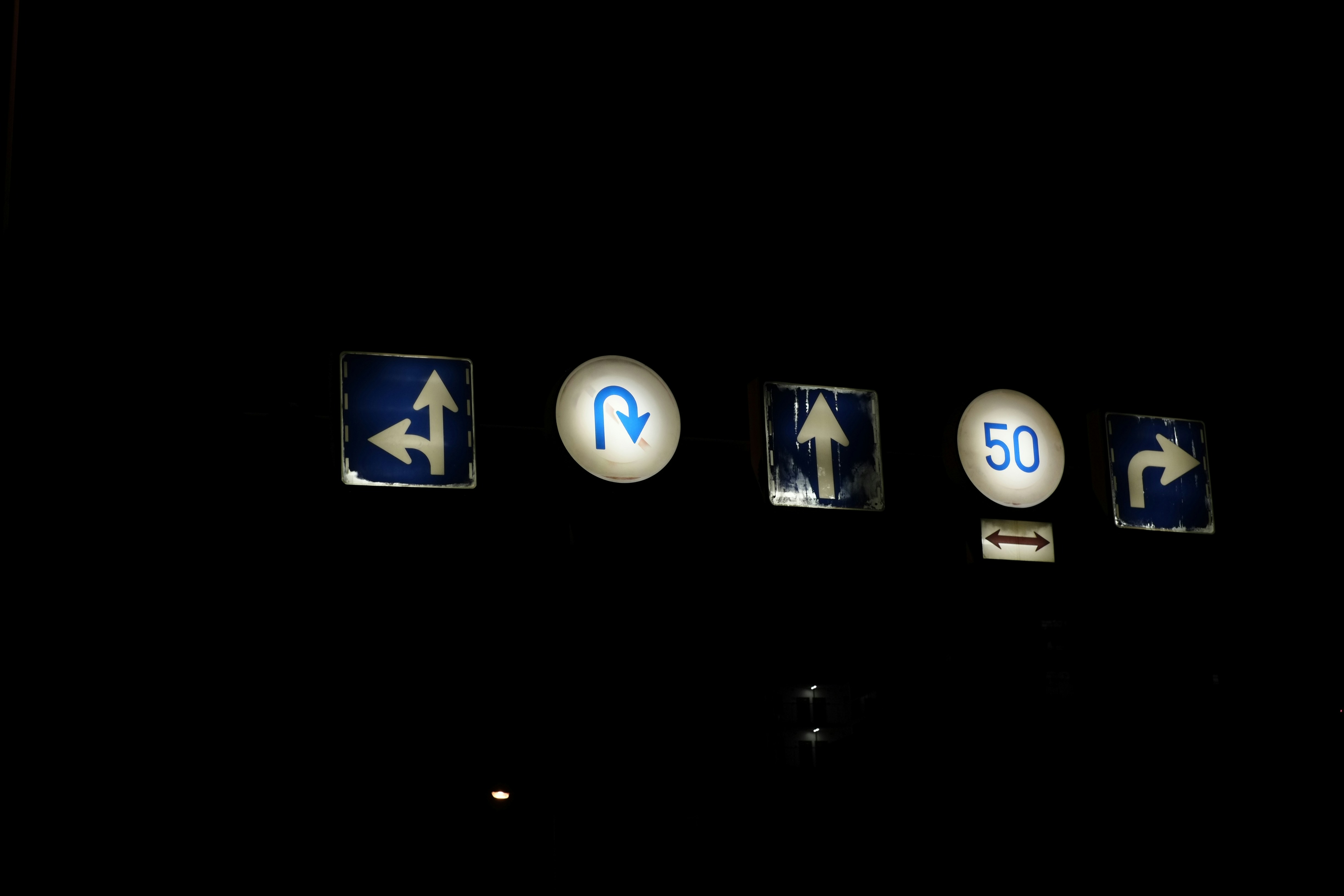 Midnight Sign Row: Subtle Arrows in a Darkened Street