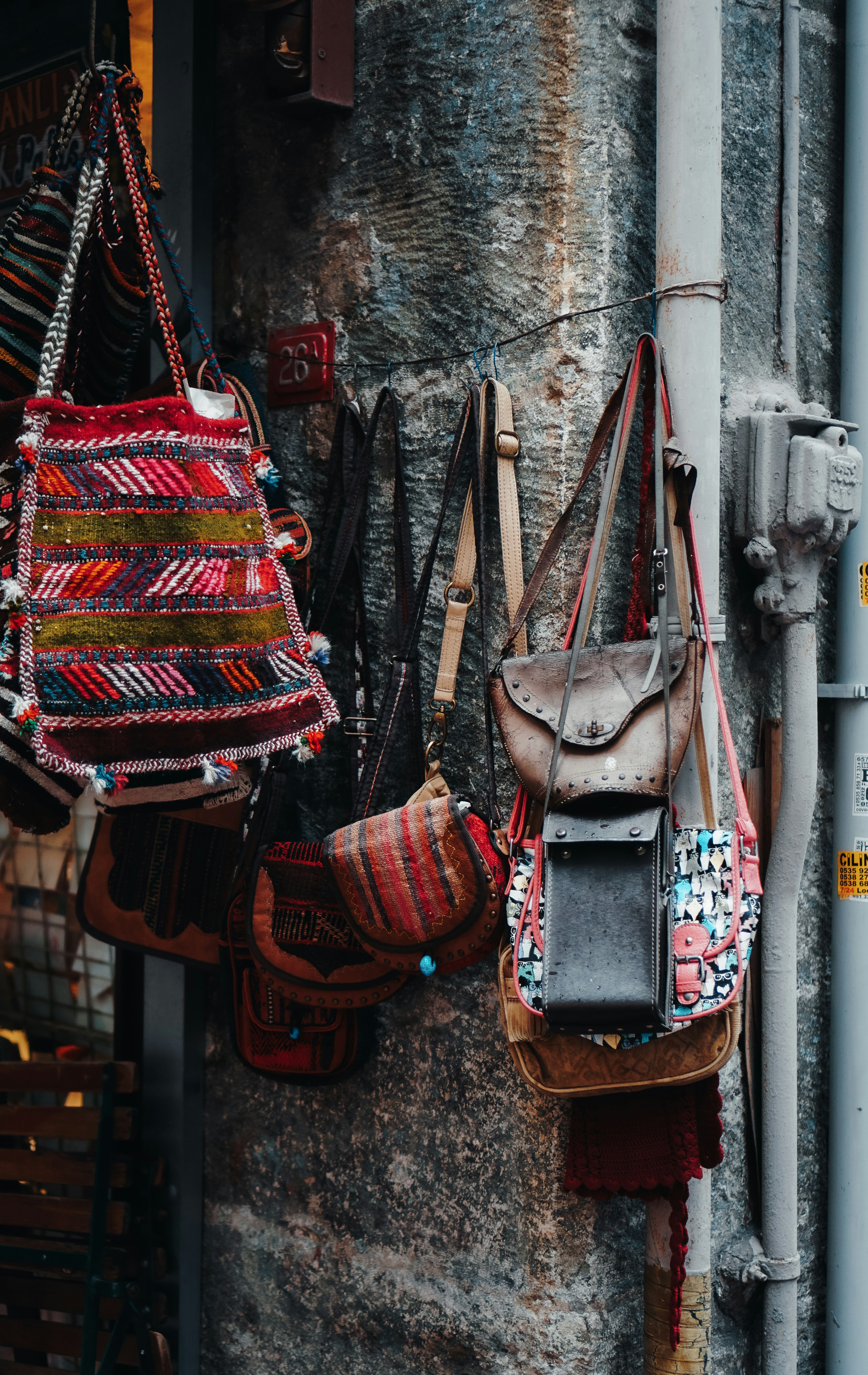A bunch of purses hanging on a wall photo – Free Street Image on Unsplash