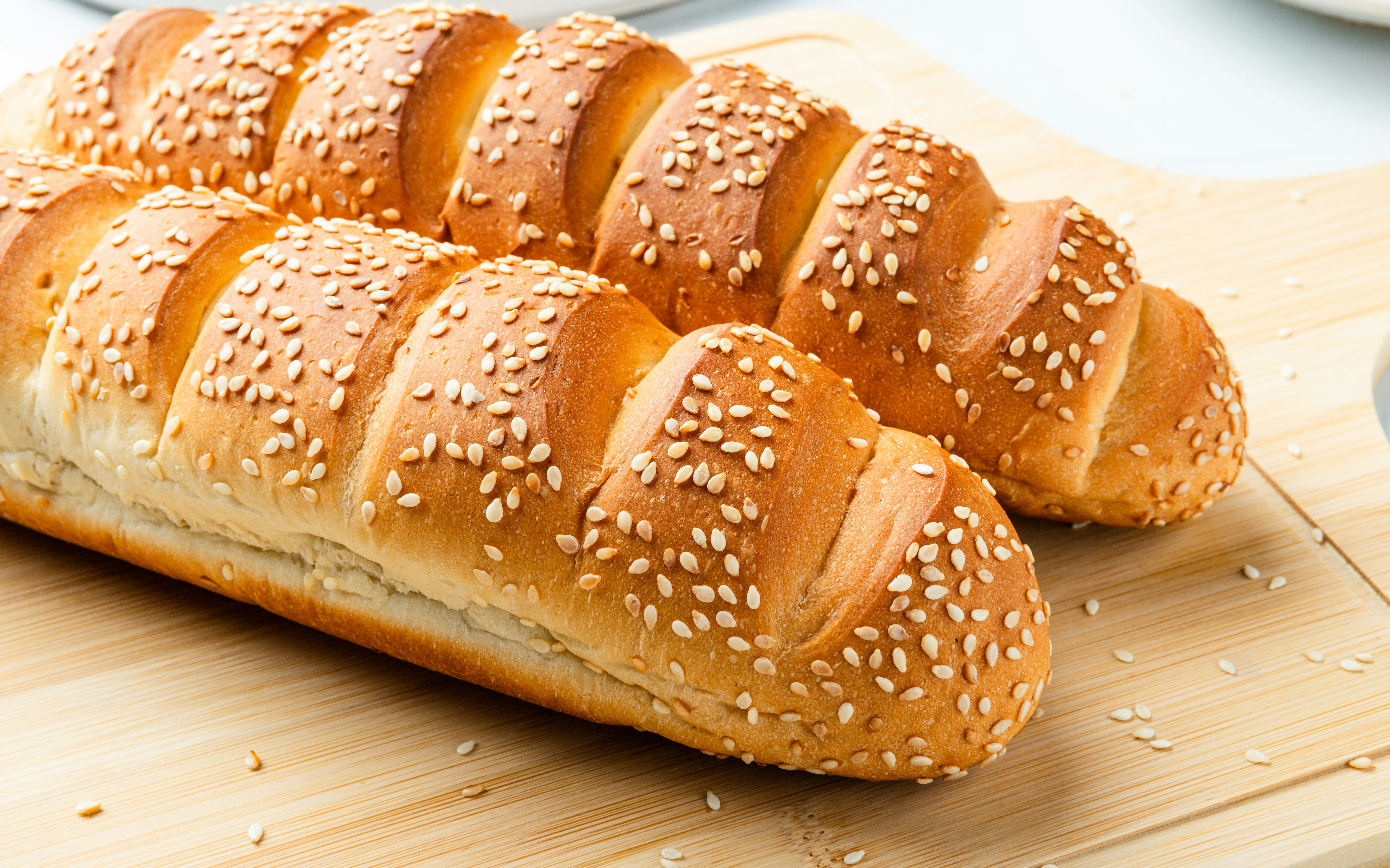 Golden Sesame Buns Recline on a Rustic Wooden Cutting Board
