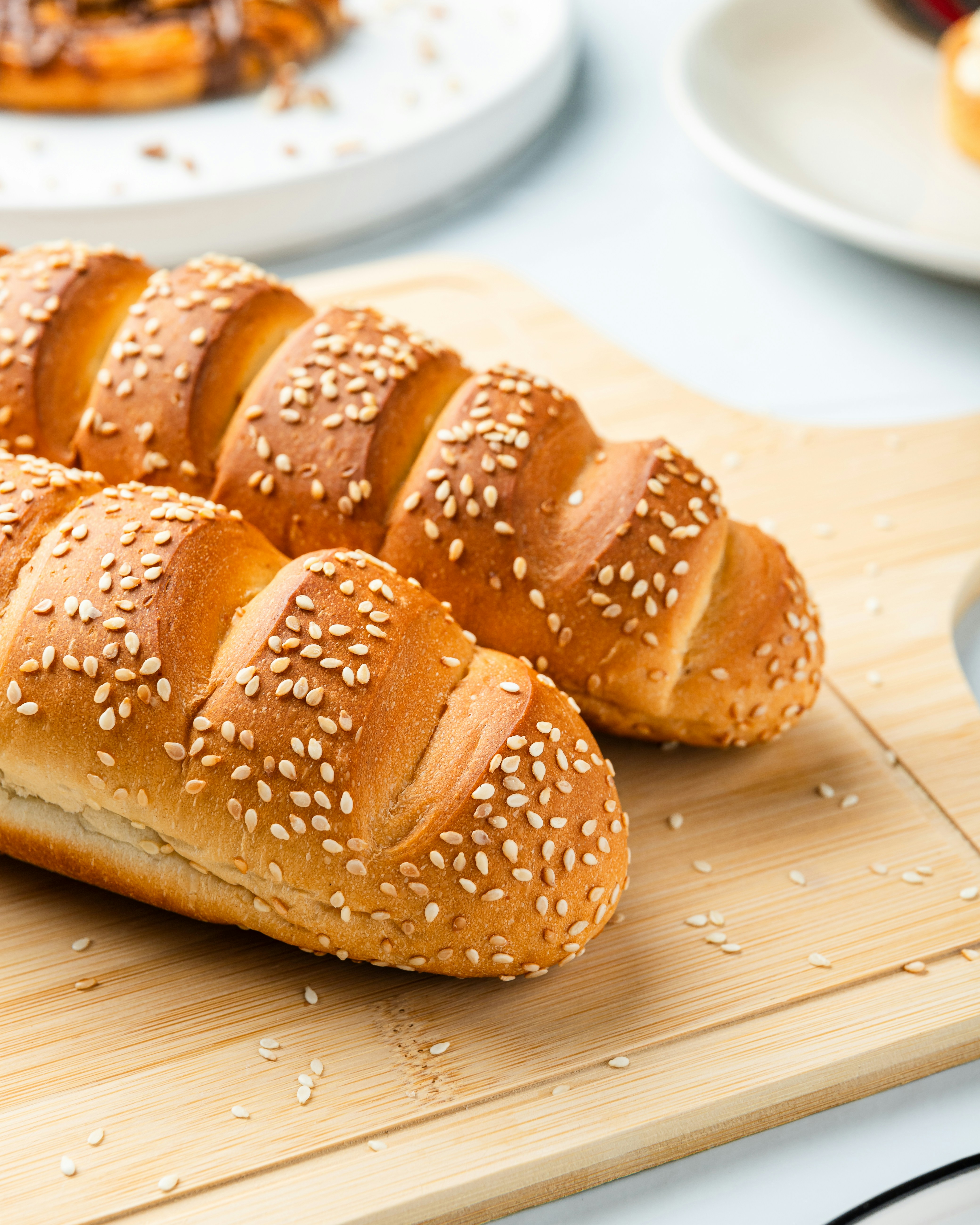 Golden Sesame Buns on a Quiet Wooden Board