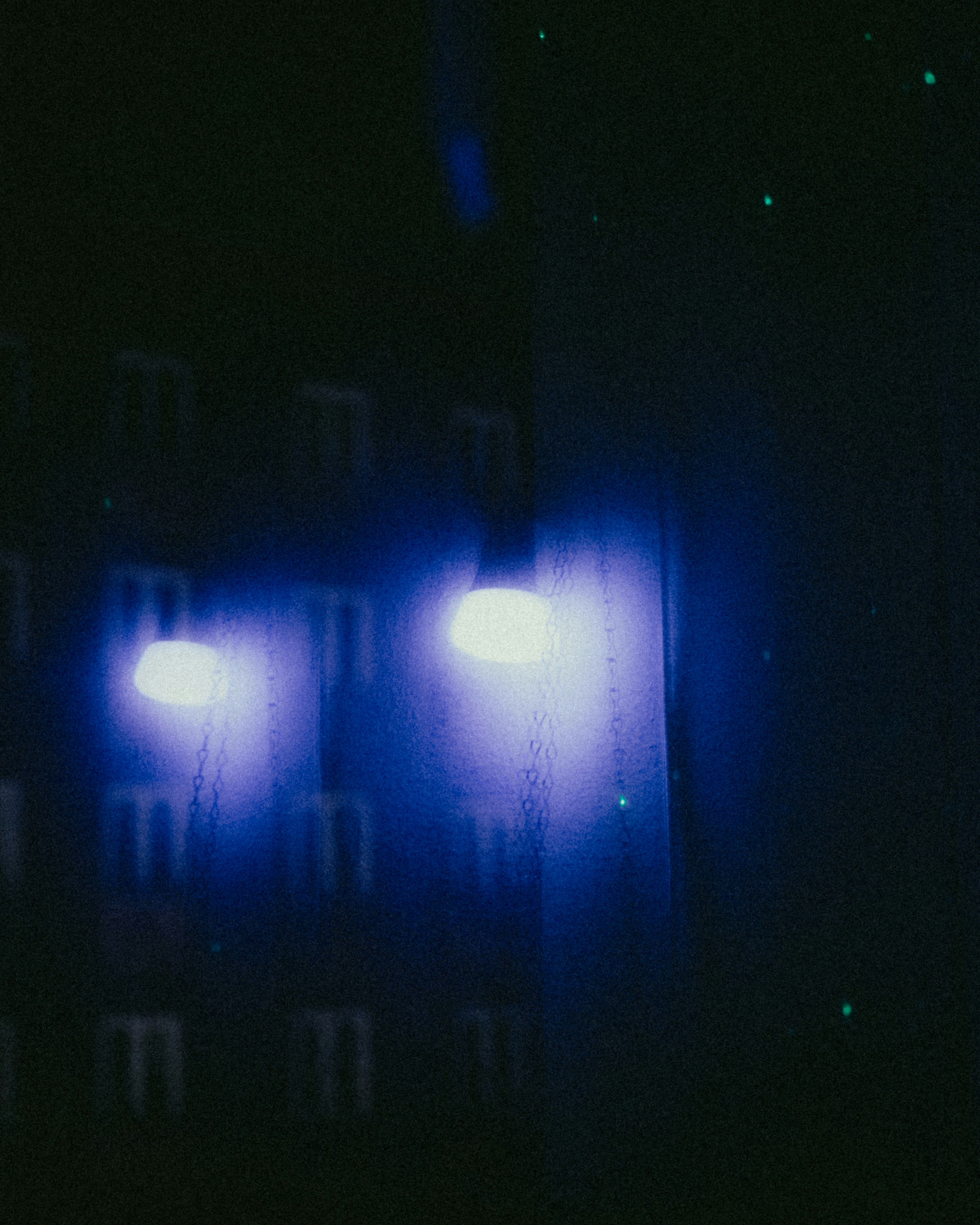 Twin Blue Streetlamps Casting Velvet Night on a Shadowed Facade