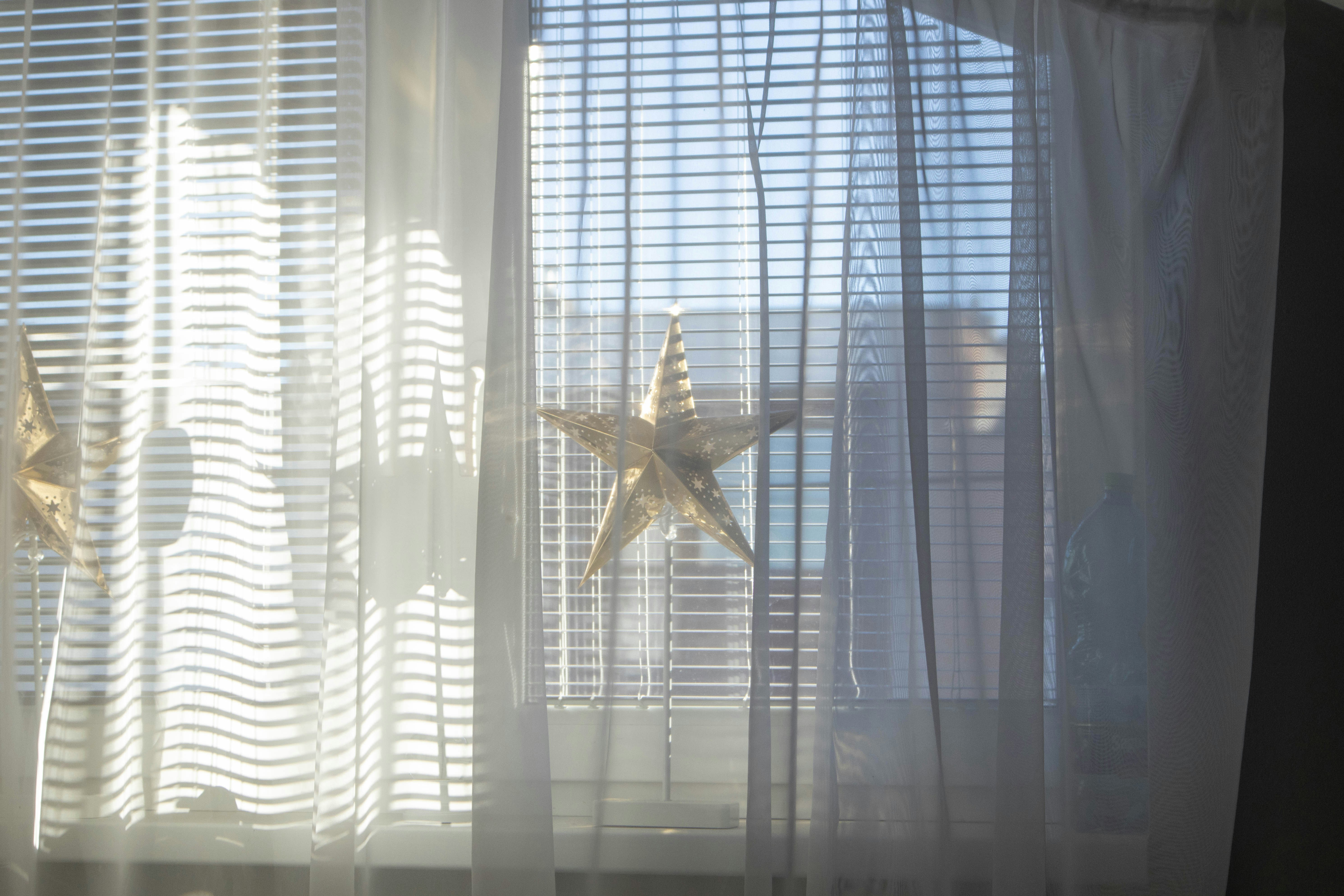 Soft Morning Light and Star Ornaments Framed by Sheer Curtains