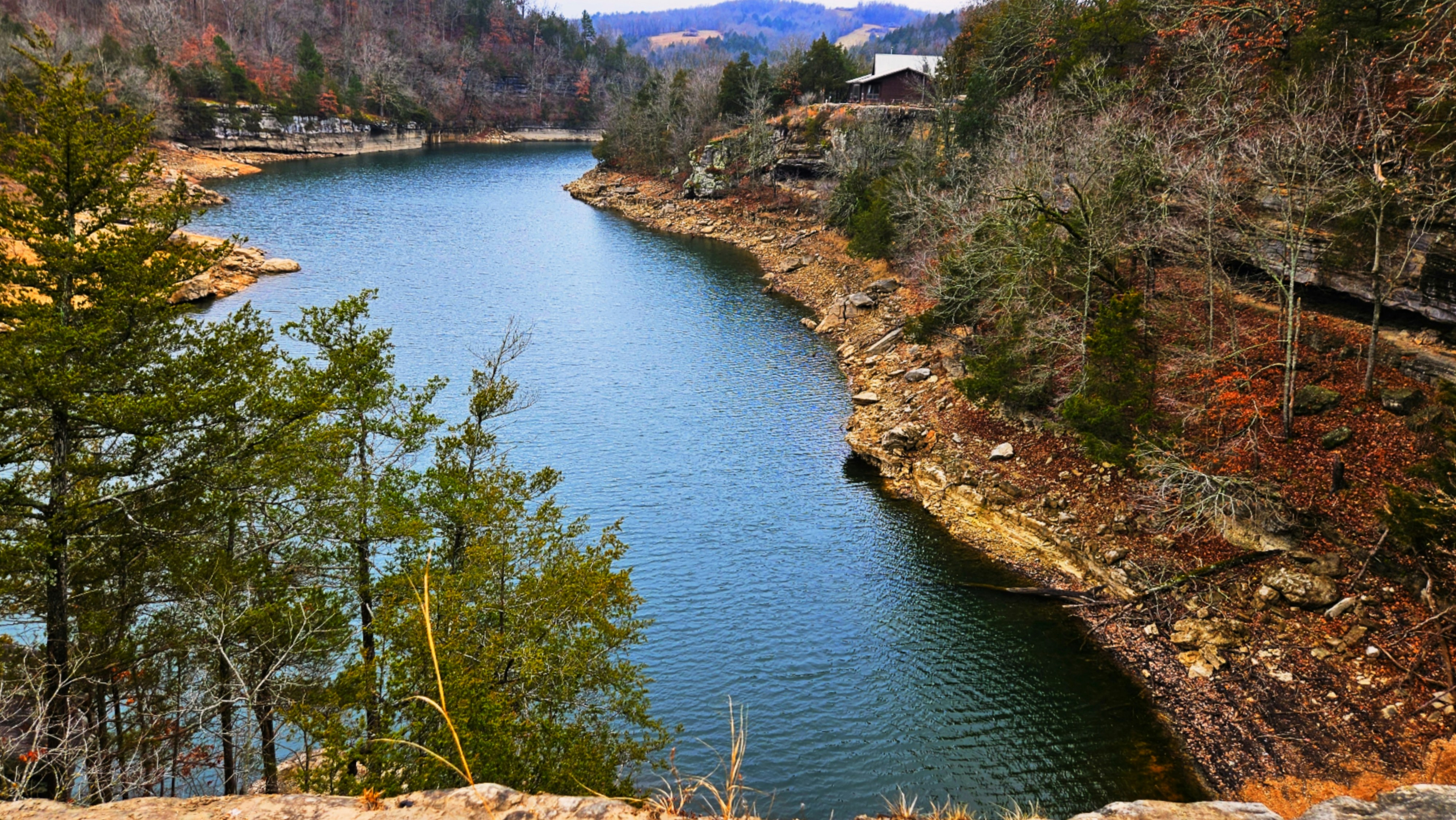Serene river bend: autumn foliage framing a tranquil blue inlet