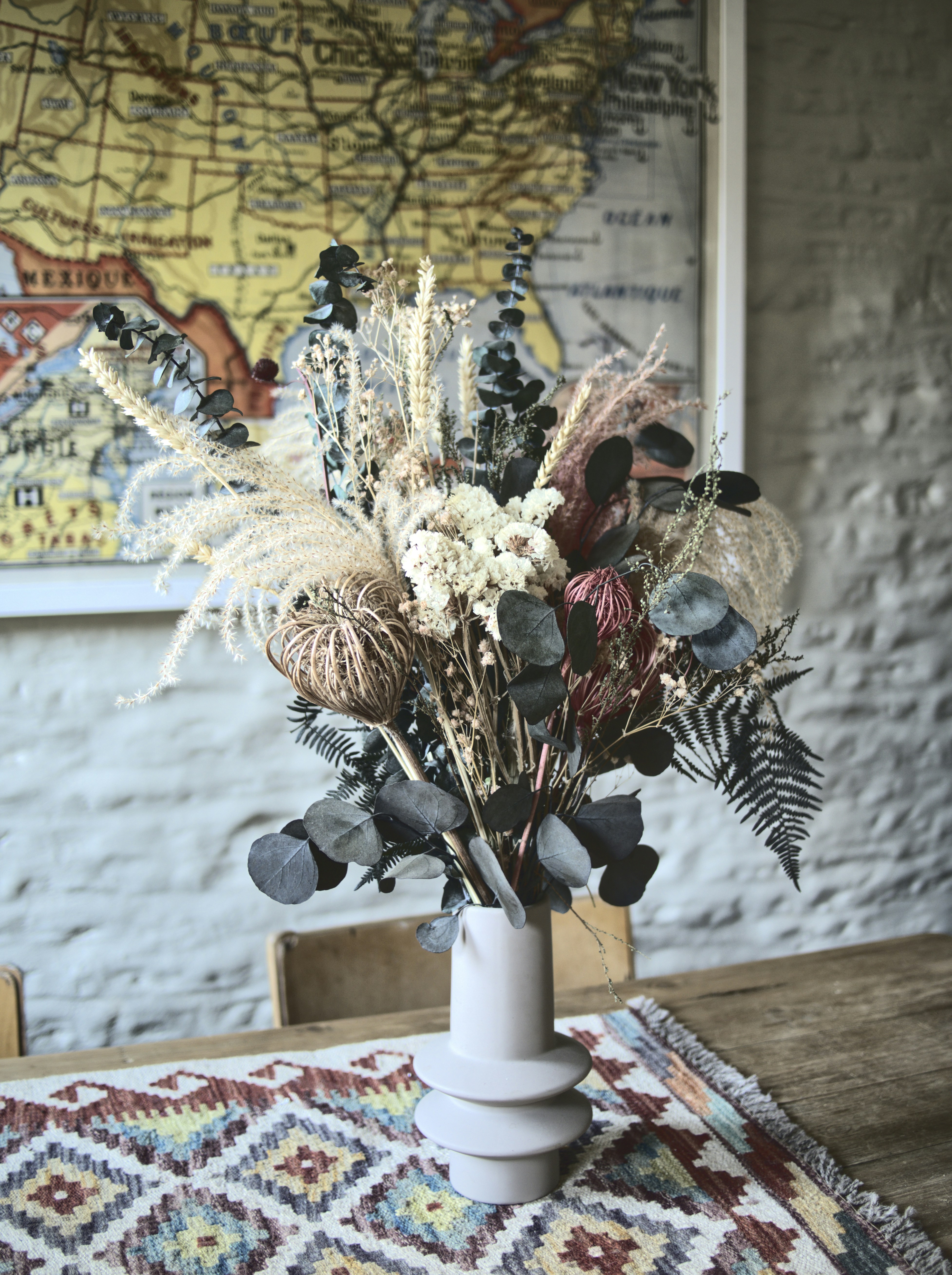 Dried Bouquet Portrait: A Ceramic Vase Before a Vintage World Map