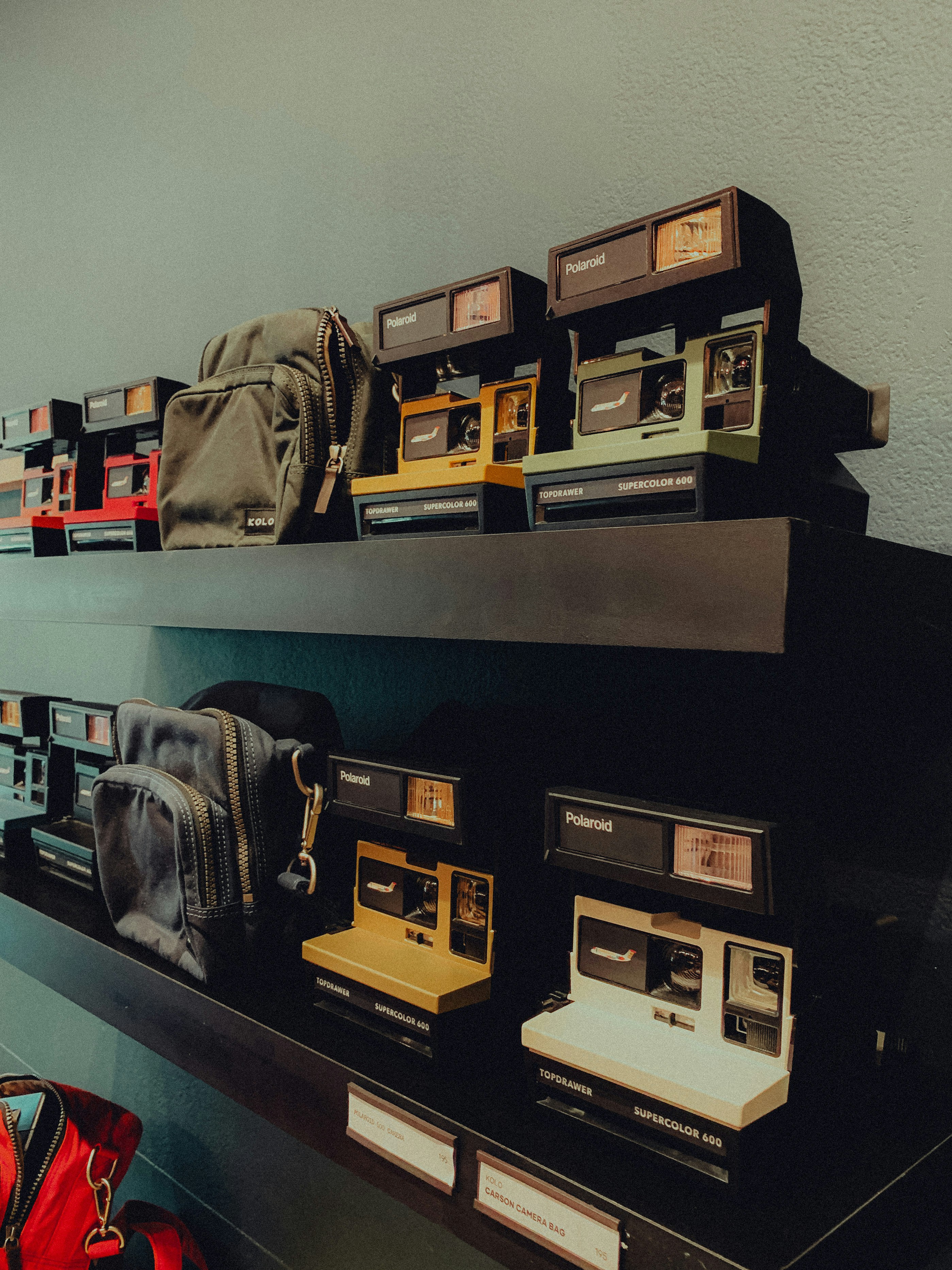 Shelf of Instant Classics: A Quiet Display of Polaroid Cameras and Bags