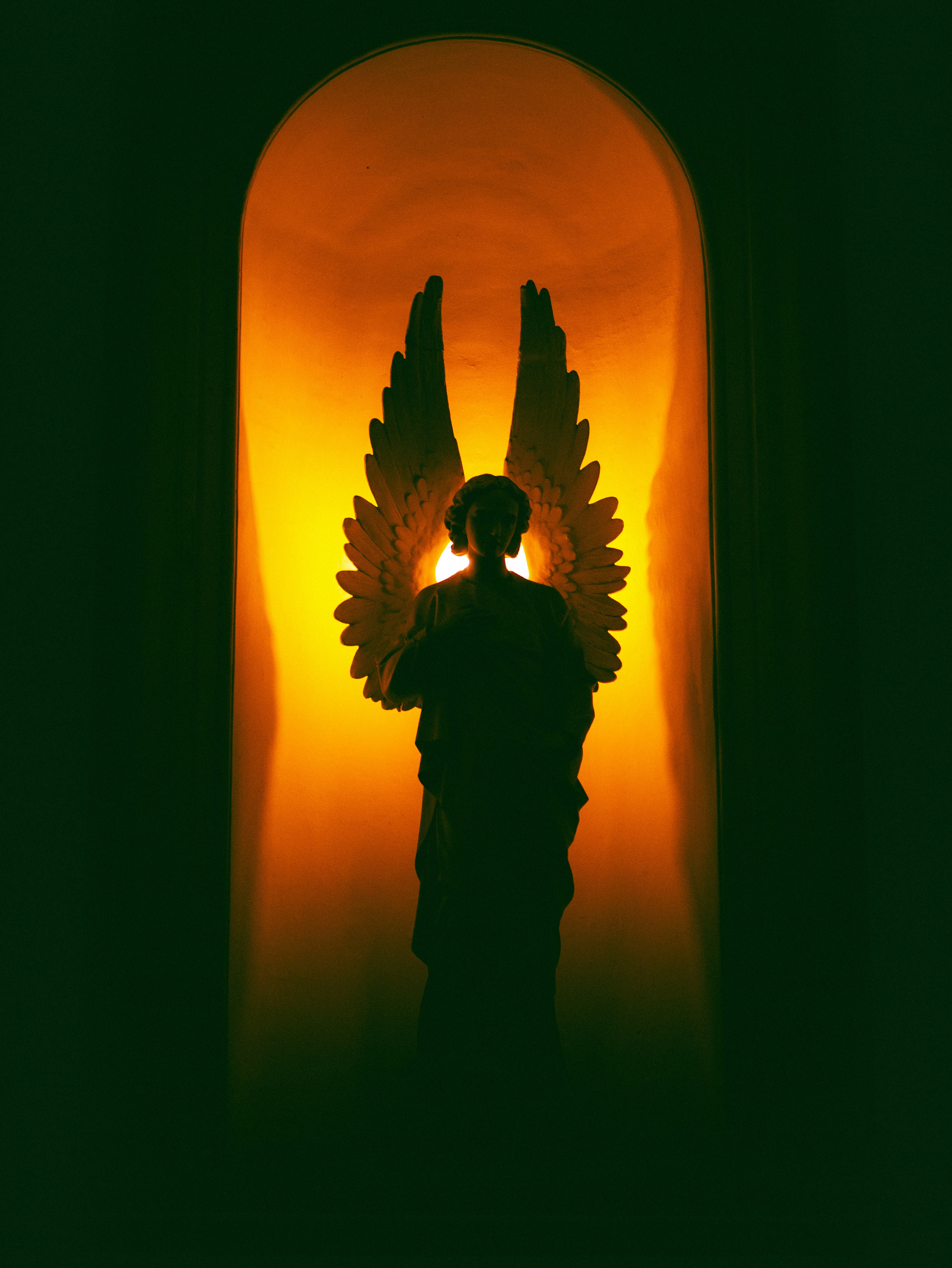 Ember Arch: Backlit Angel Silhouette Beneath a Fiery Gateway