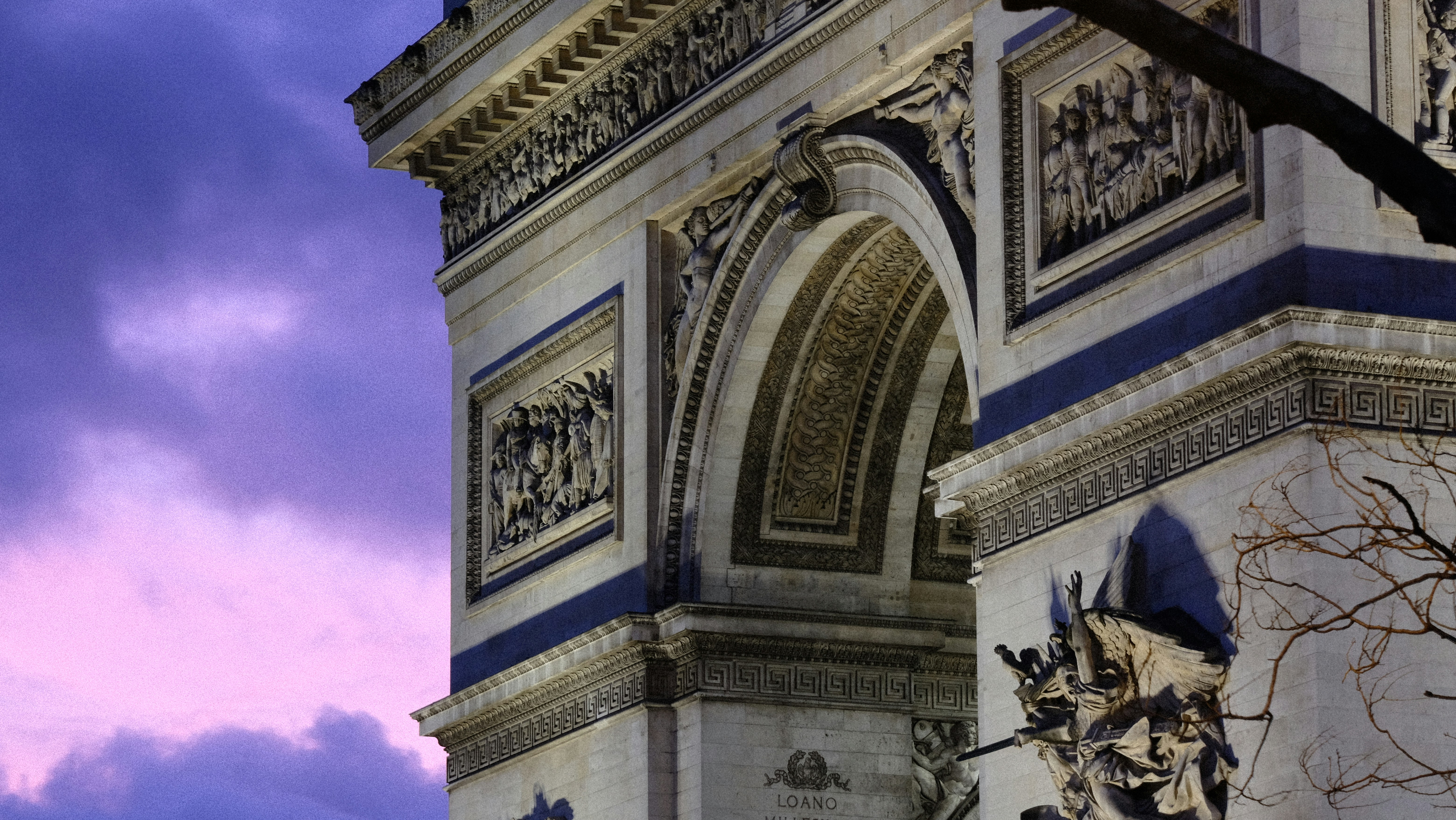 The intricate details of the Arc de Triomphe illuminated against a twilight sky, showcasing its architectural splendor.