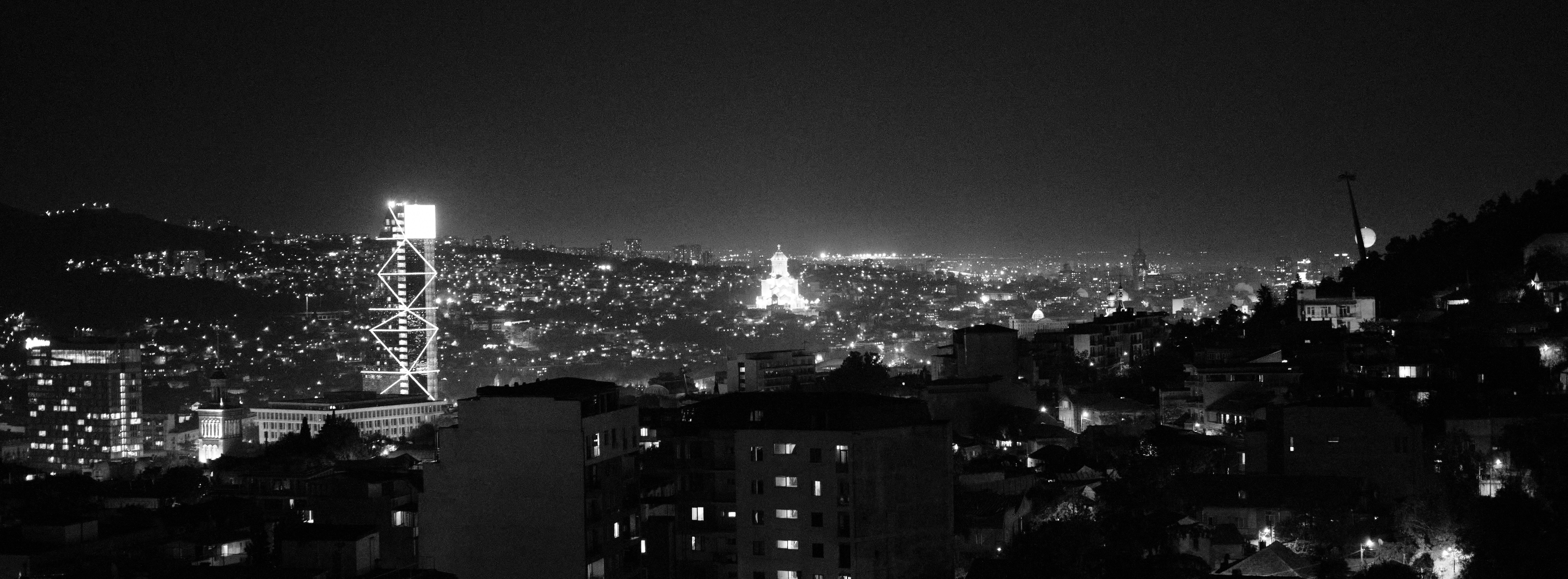 Beacon Over the Hills: Night Cityscape in Monochrome