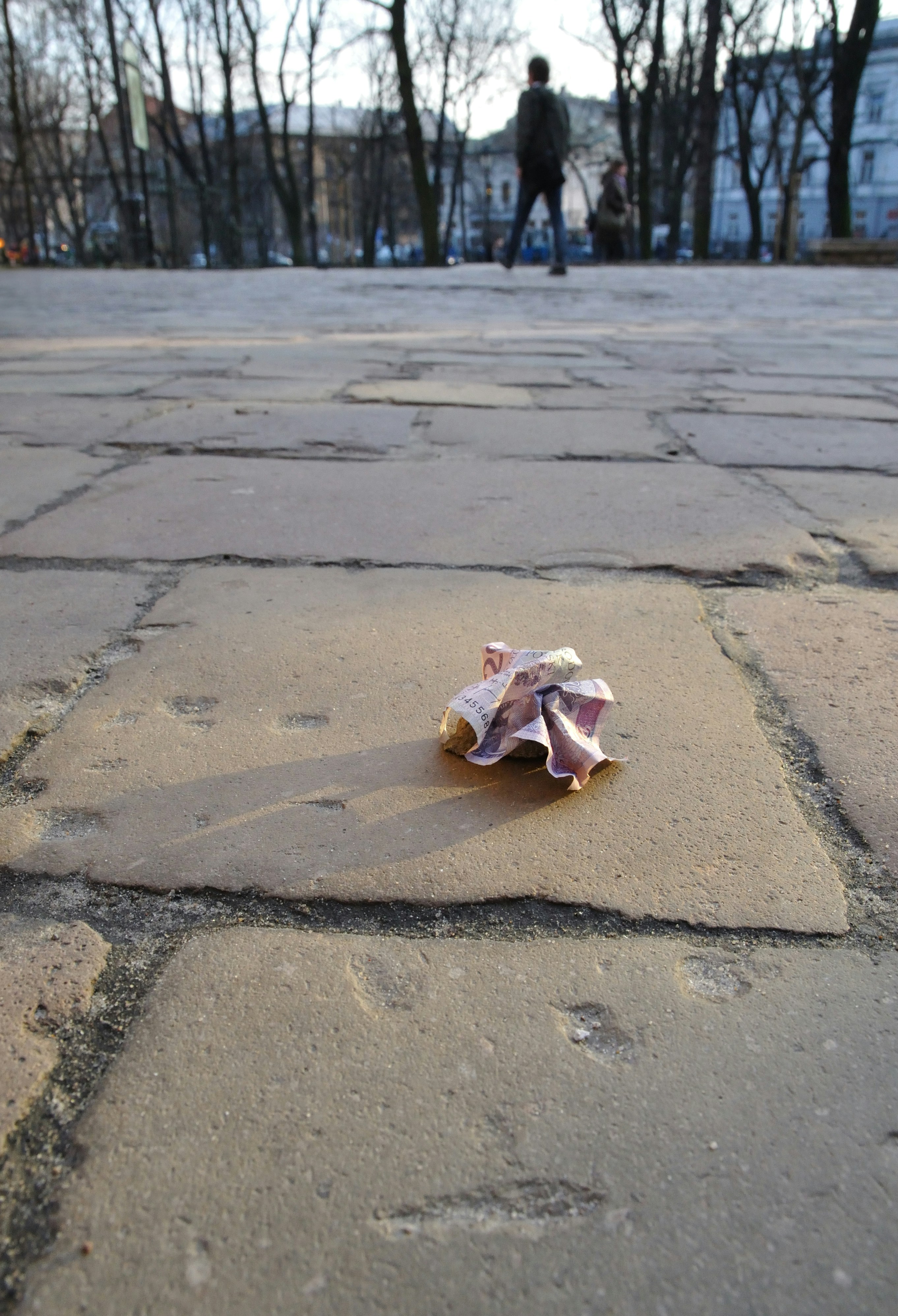 A crumpled piece of paper sitting on the ground photo – Free Walking ...