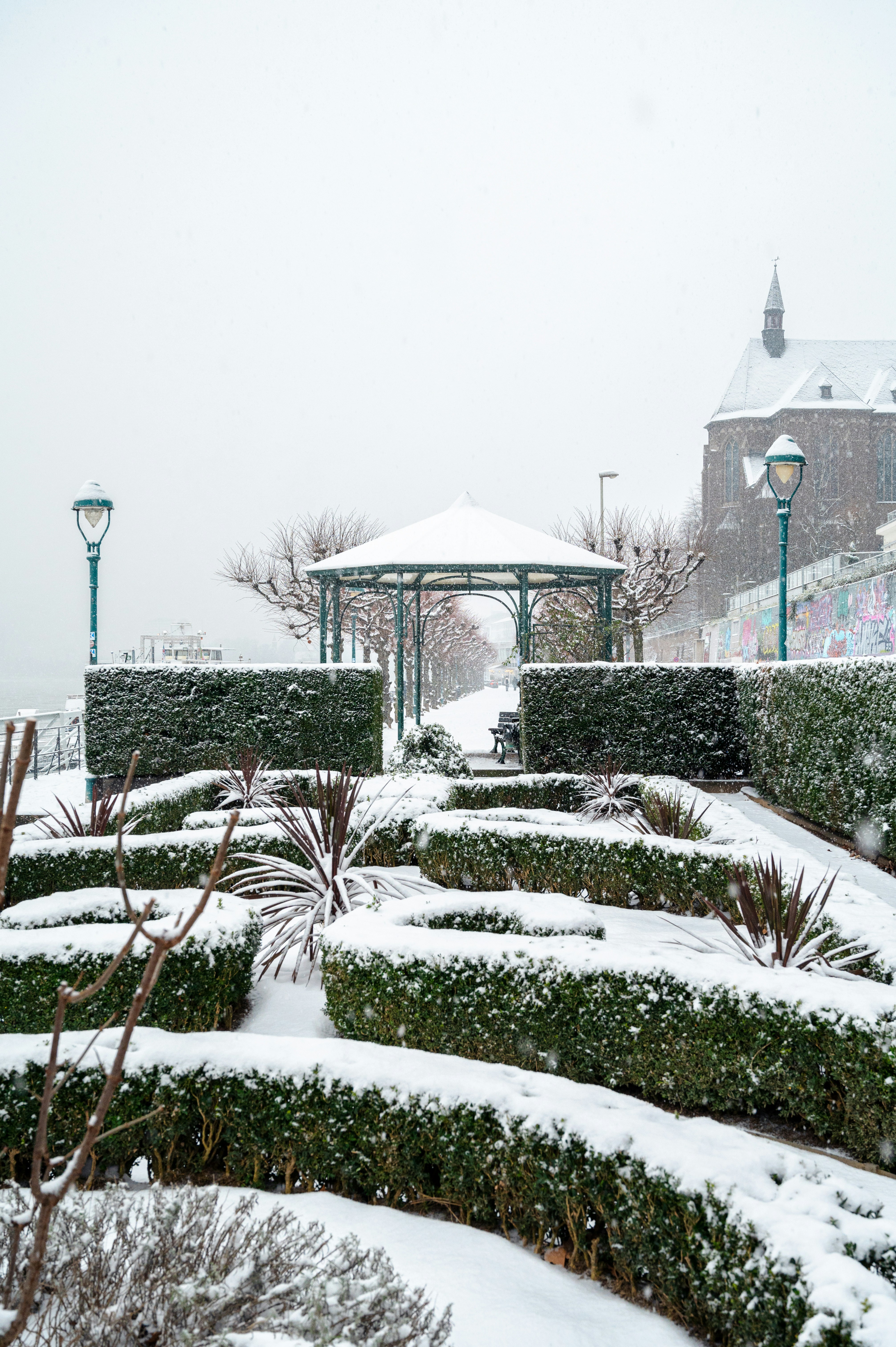 A snow covered garden with a gazebo in the background photo – Free Bonn ...