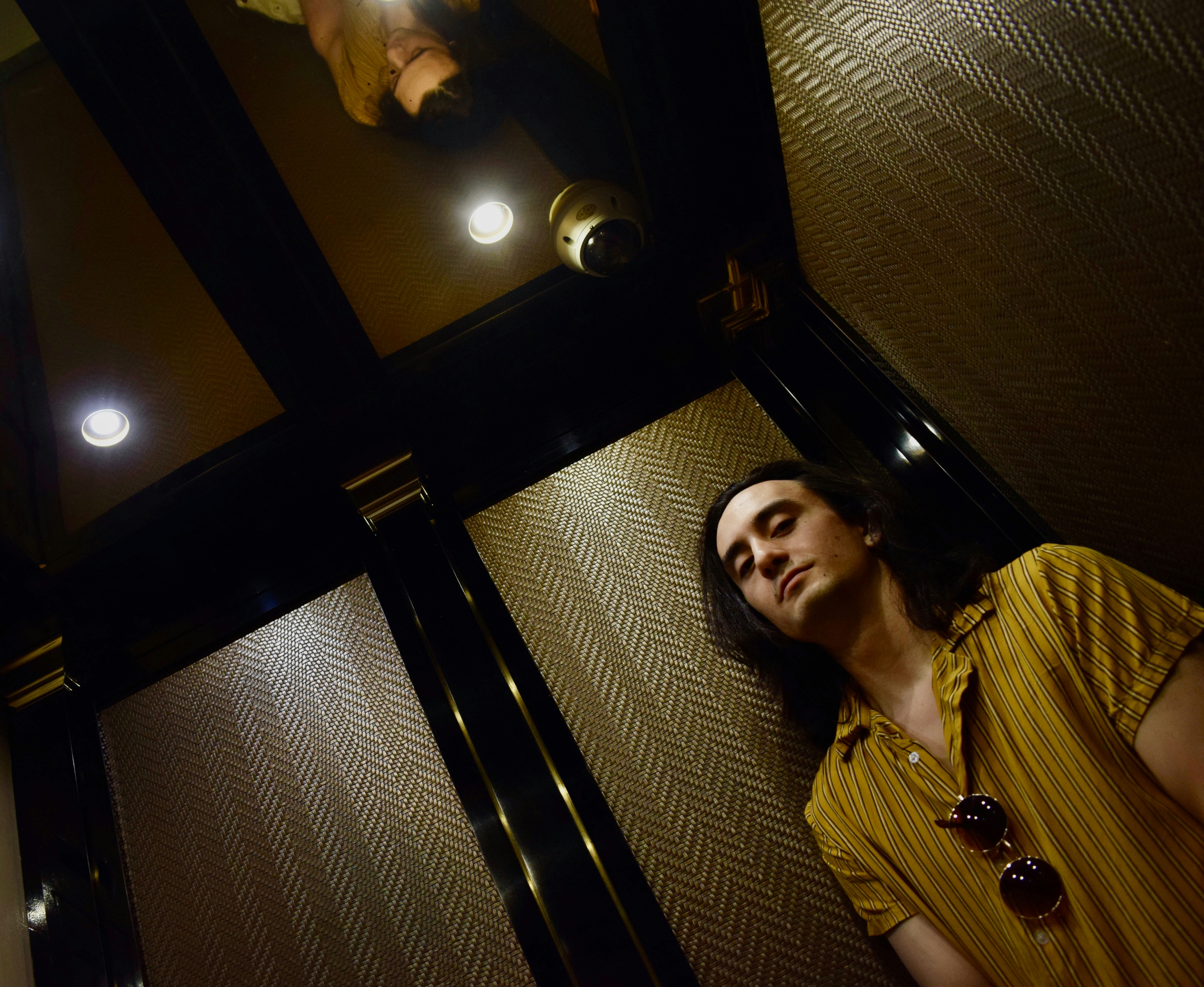 Elevated Perspective: A Casual Portrait in Neon Elevator Light