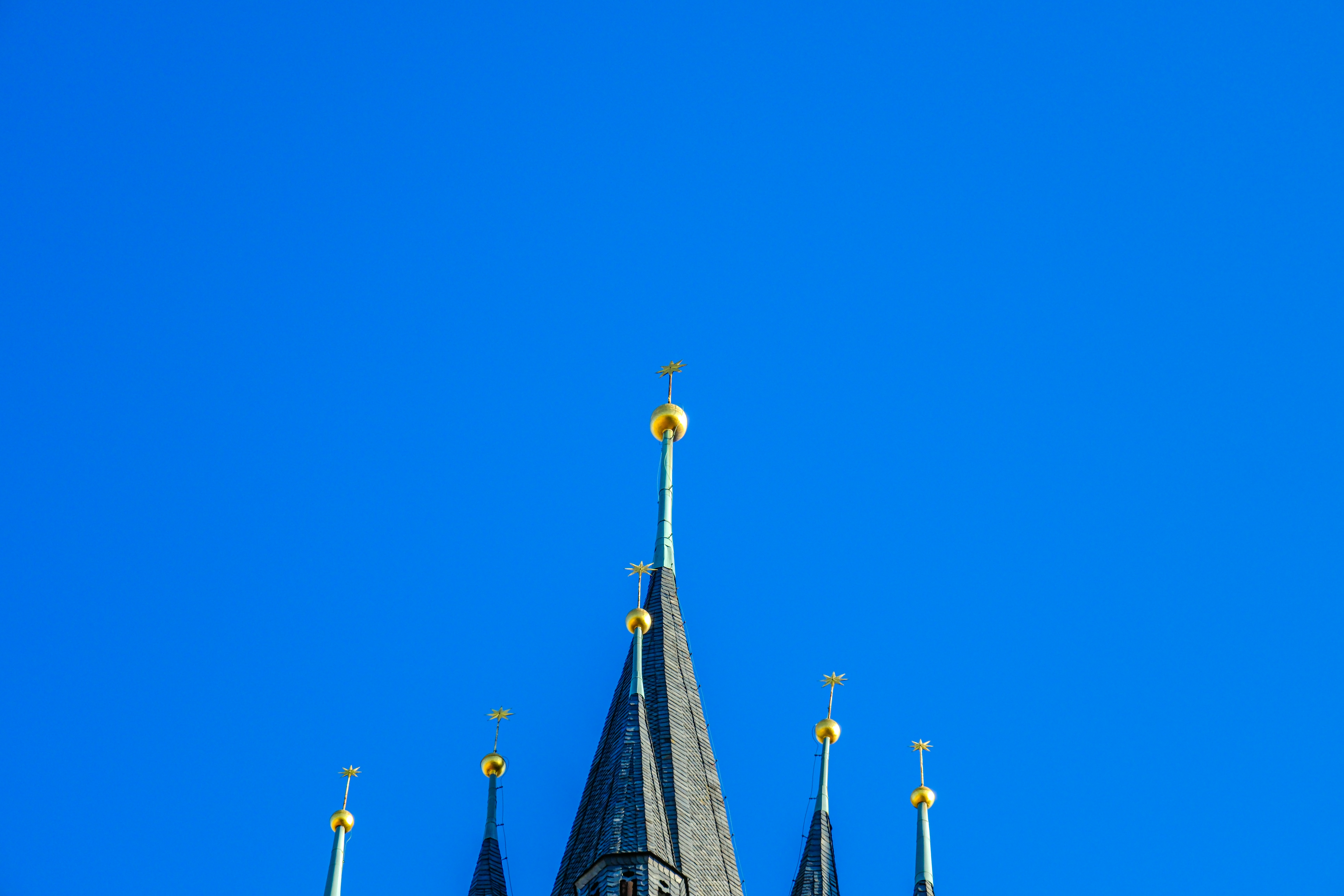 Gold-Tipped Spires Piercing a Clear Azure Sky