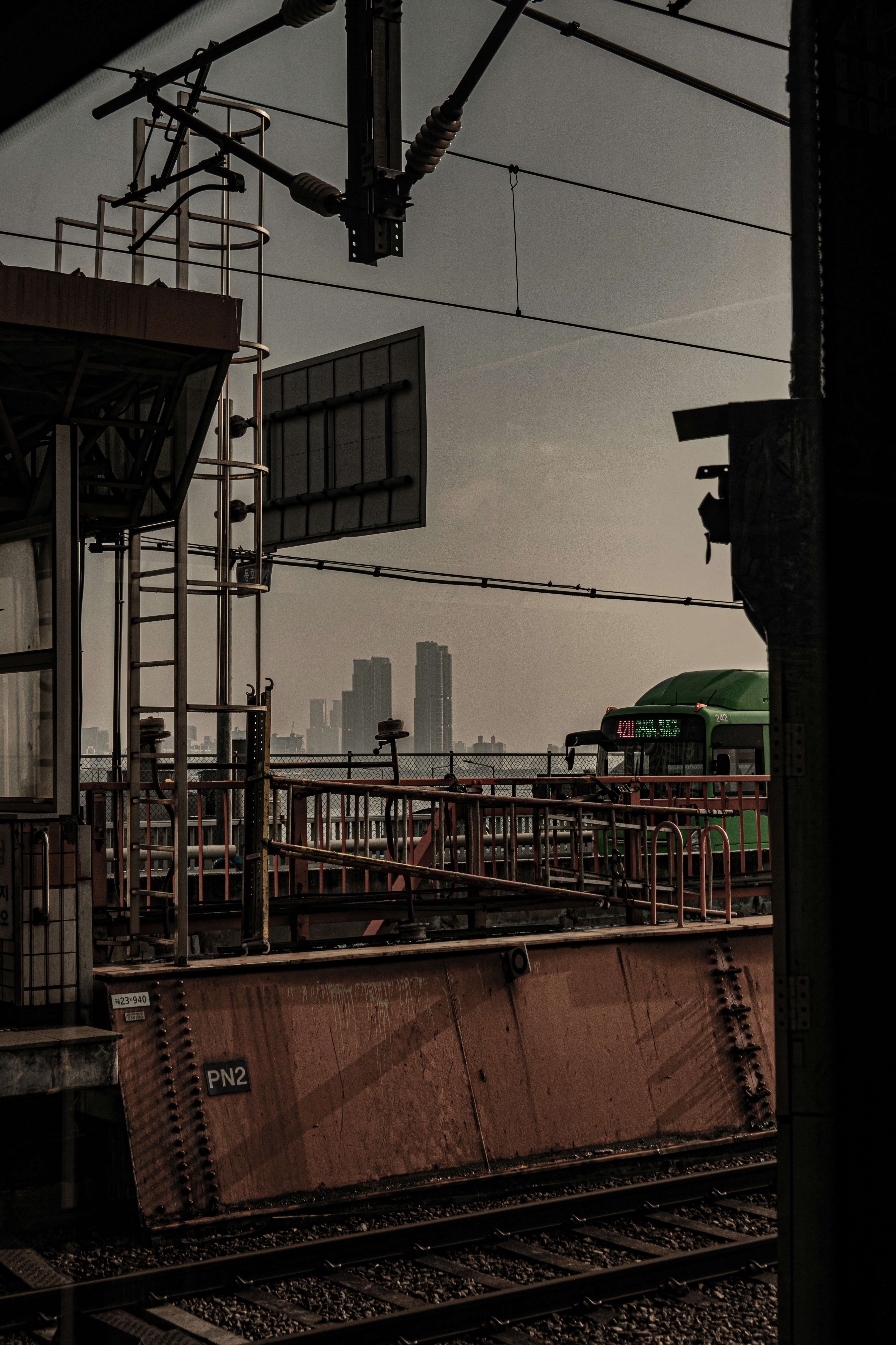 Green Engine at the Platform Edge: Industrial Lines Framing a Distant City
