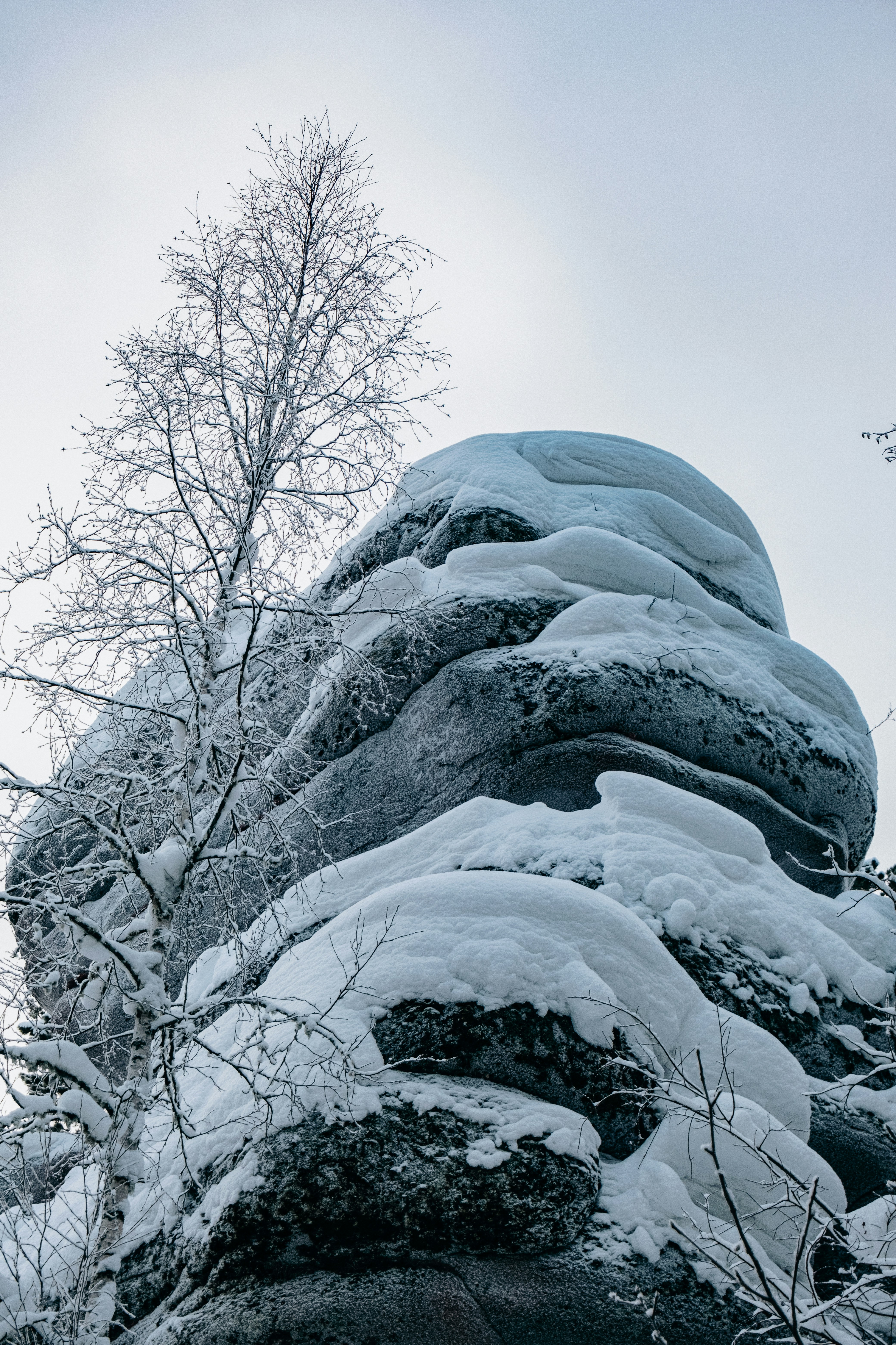 A very tall rock with some snow on it photo – Free Siberia Image on ...