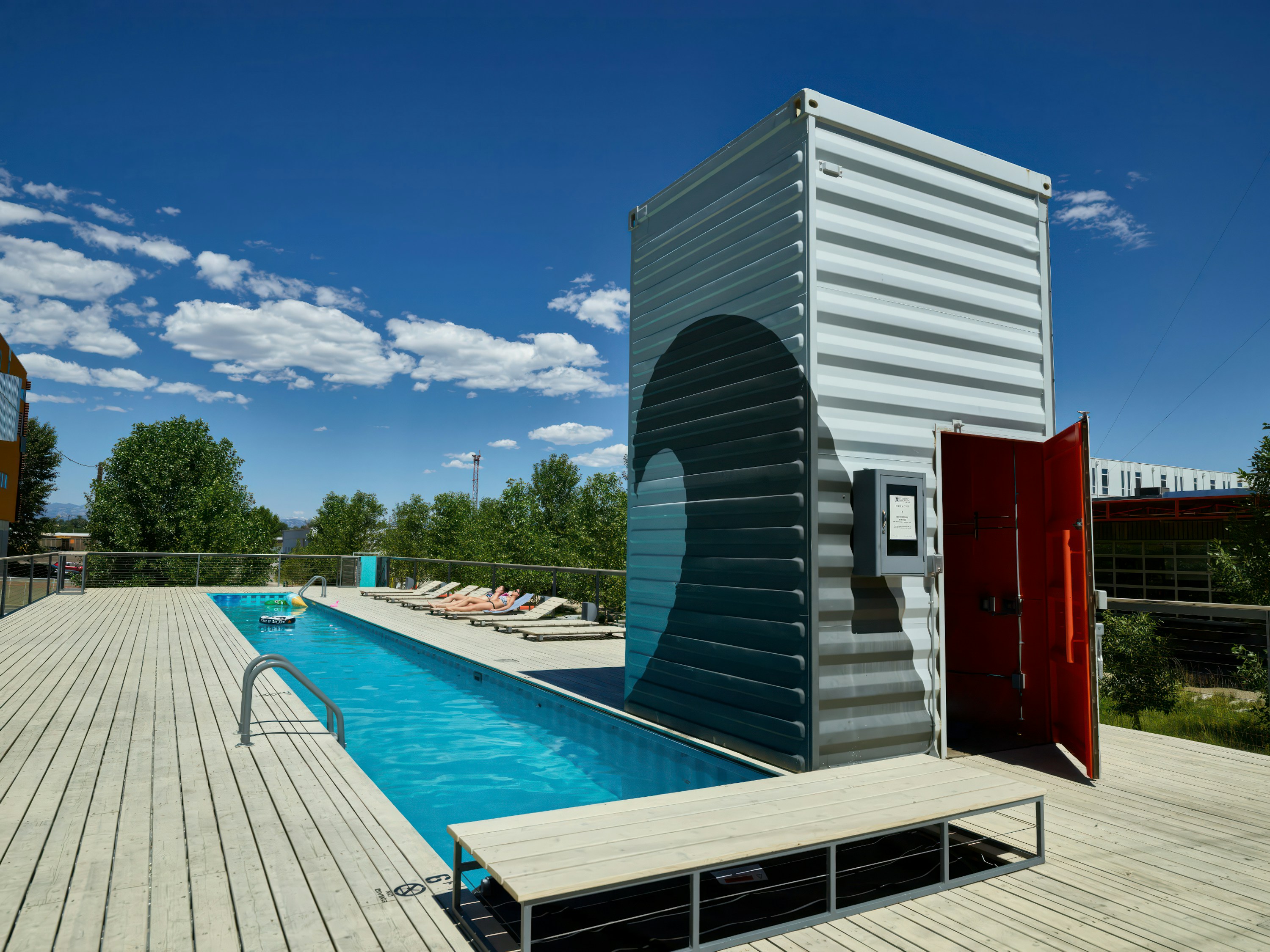 A swimming pool and supply building made of huge shipping containers in ...