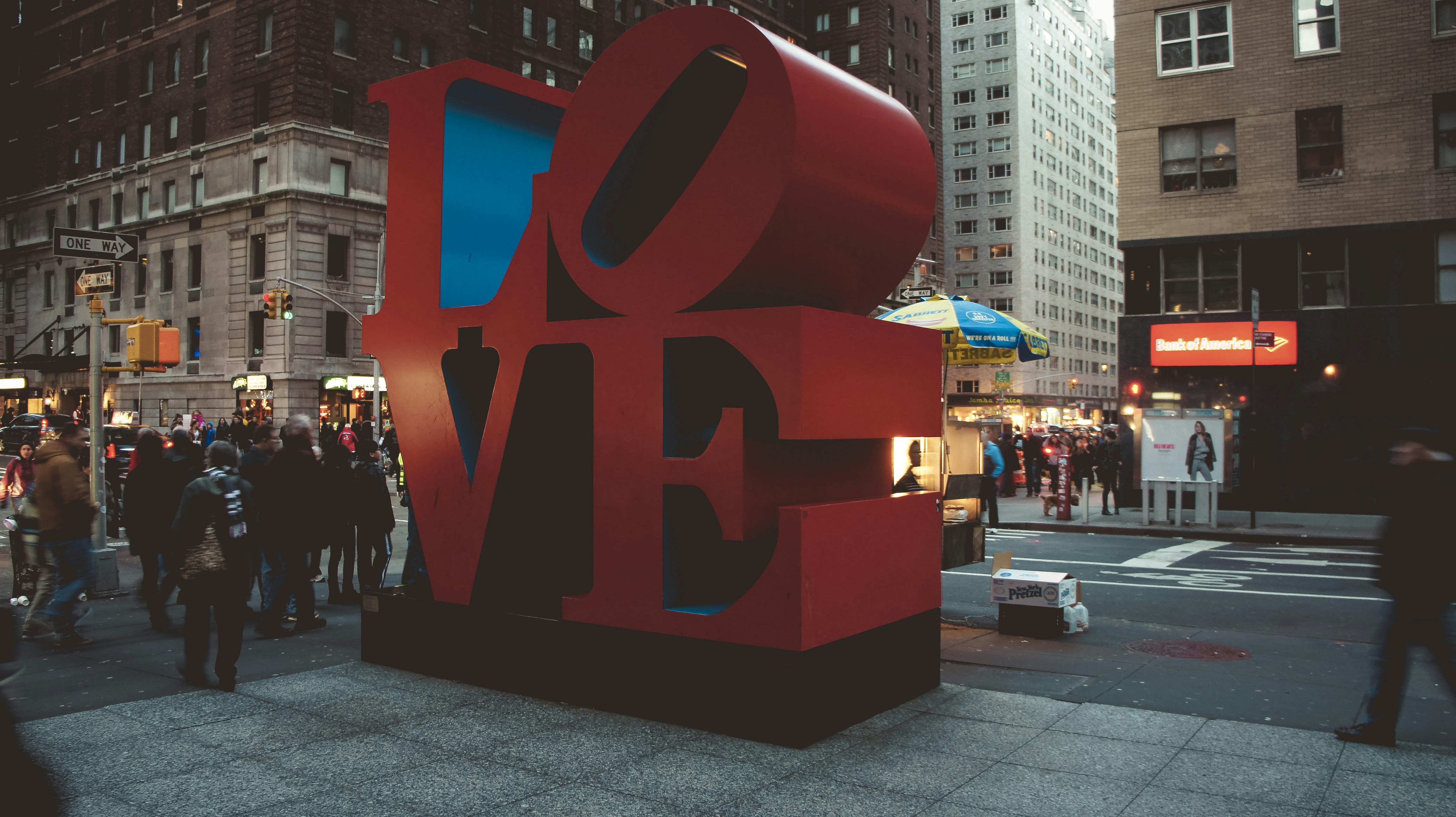 LOVE Sculpture in Motion: Neon Red Letters Amid Evening City Pulse