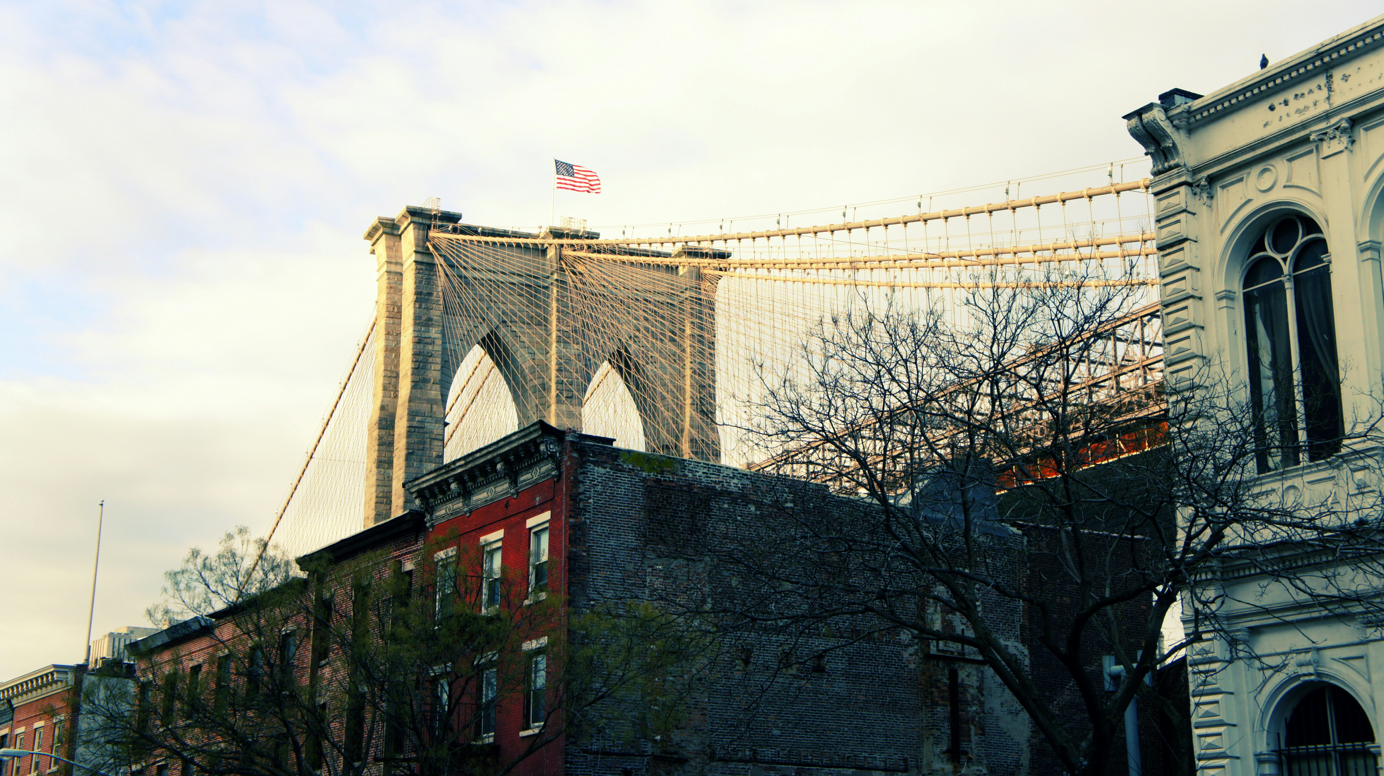 Brooklyn Bridge Towers Framing a Quiet Brick-Row Skyline