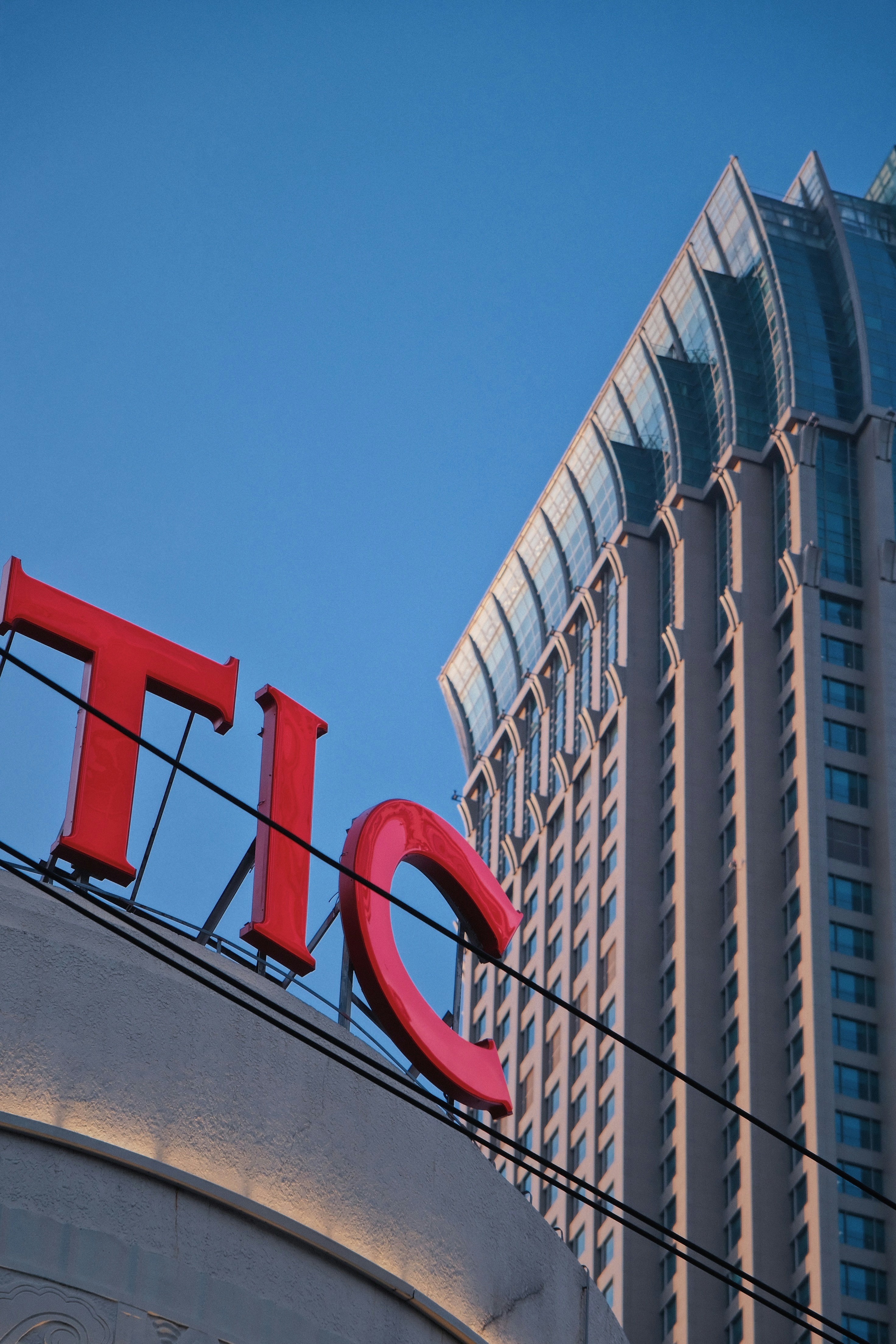 A tall building with a large red sign on top of it photo – Free City ...