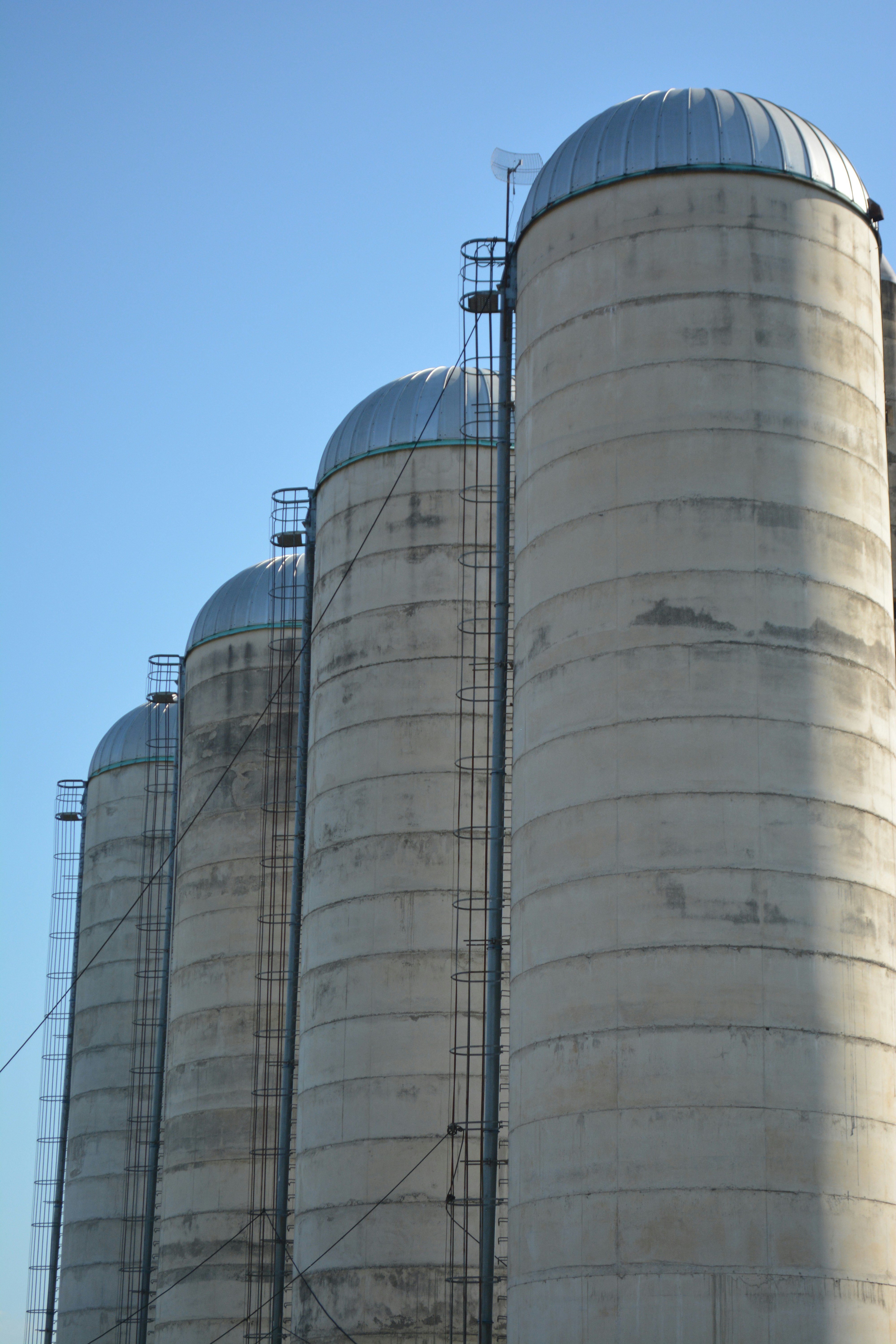 A group of large silos sitting next to each other photo – Free Factory ...