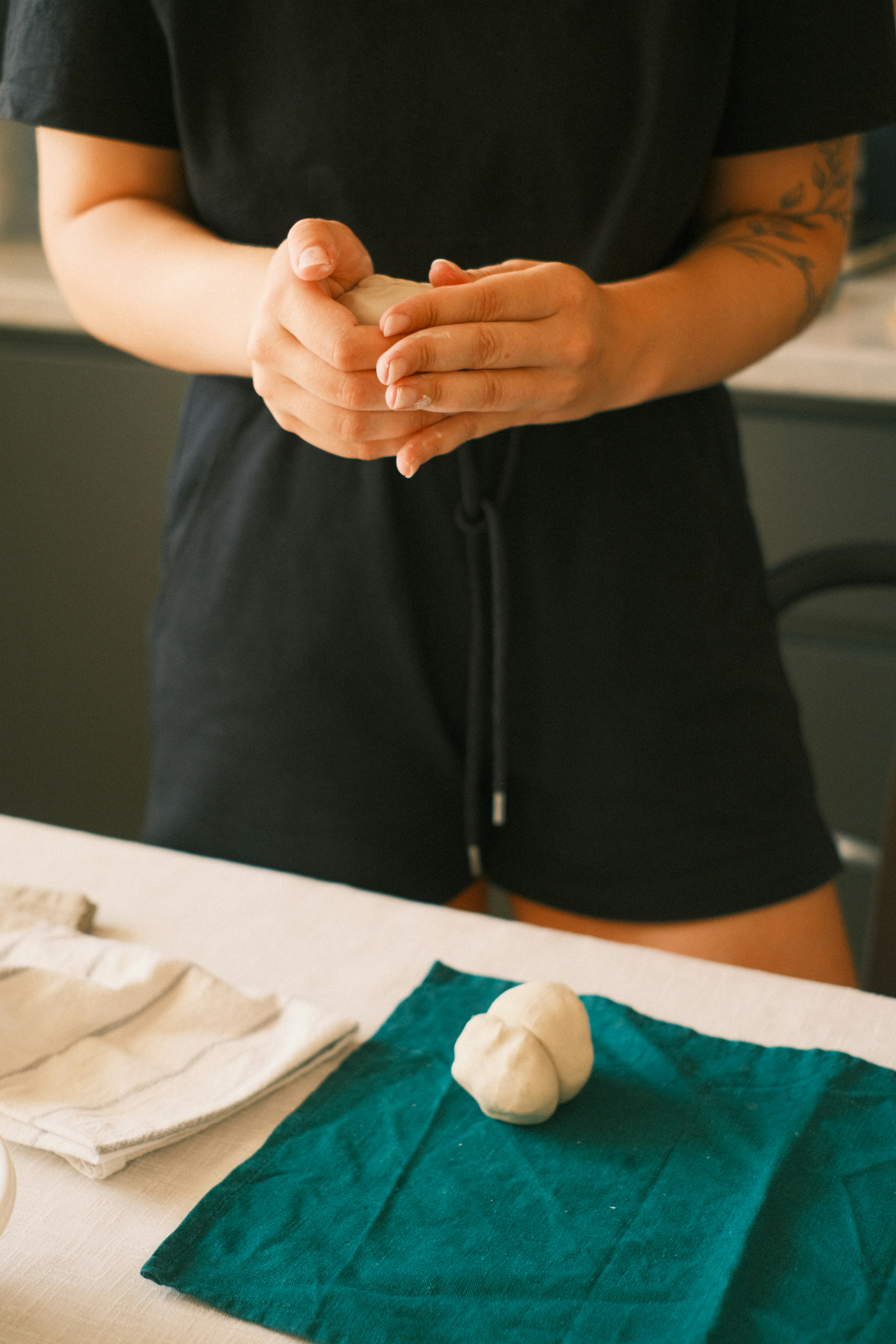 Between Fingers and Dough: A Quiet Kitchen Moment on Teal Linen
