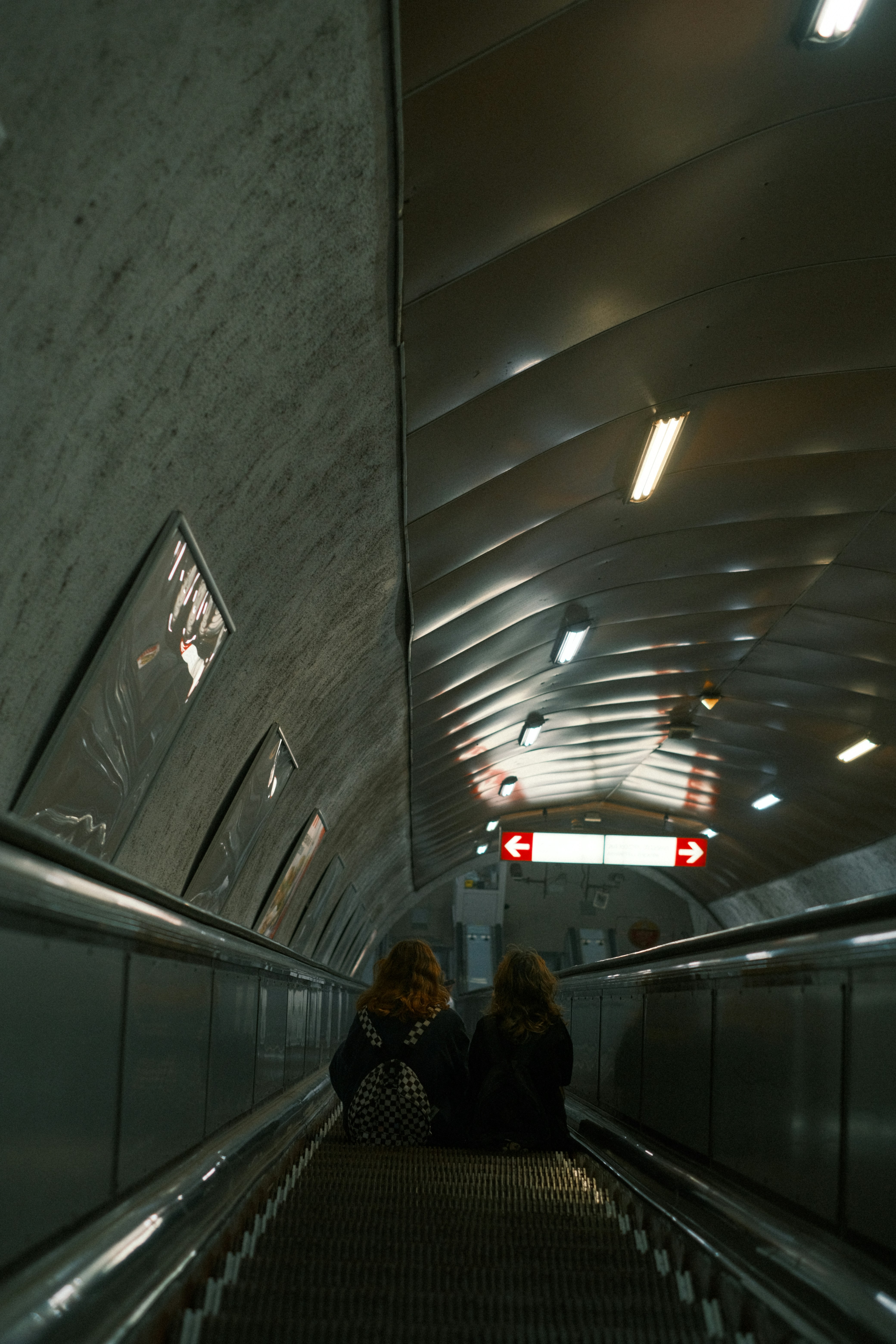 Escalator Convergence: Two Figures in a Concrete Subway Tunnel