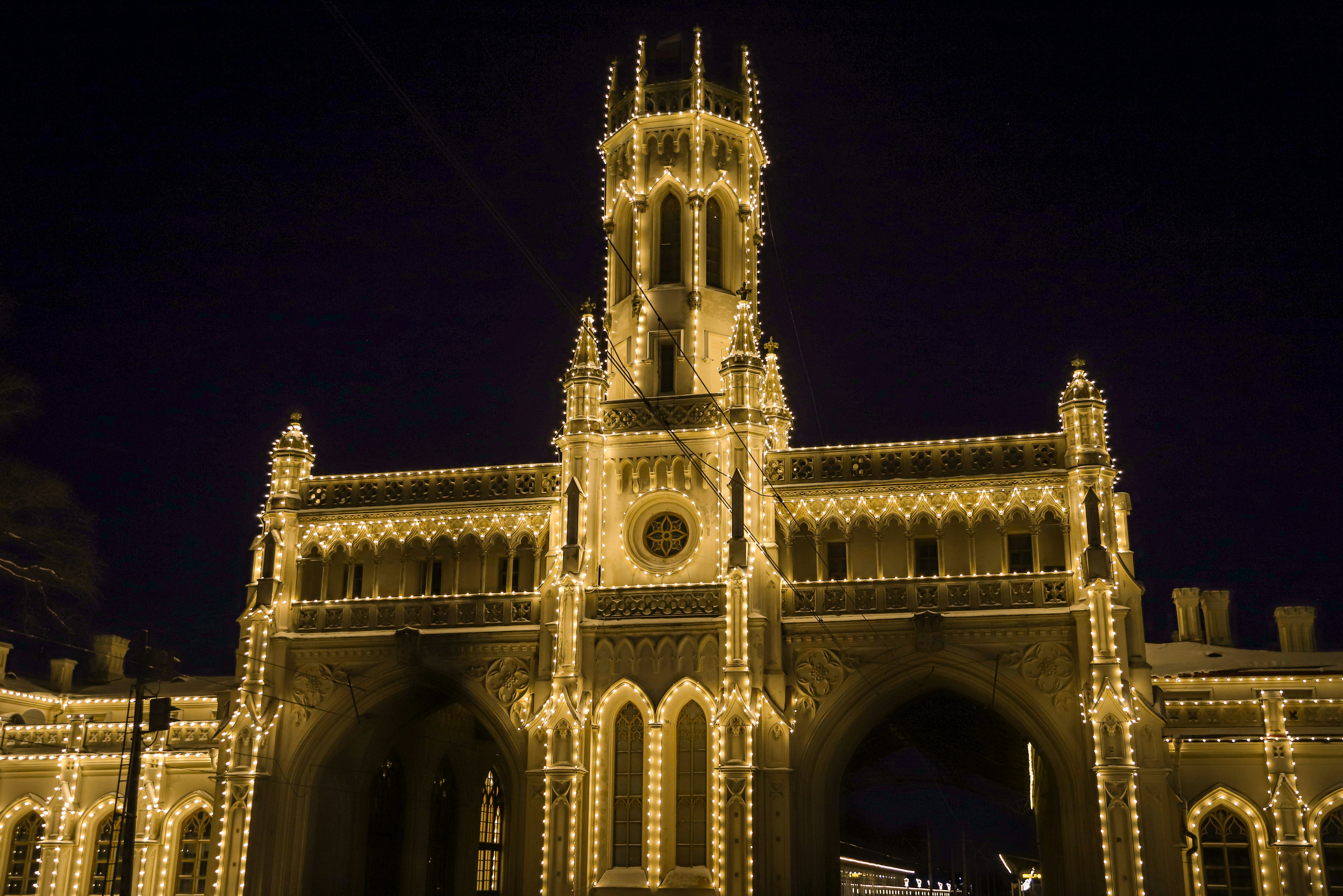 Glow-Lit Gateway: Nighttime Archway Adorned in Warm Ornaments