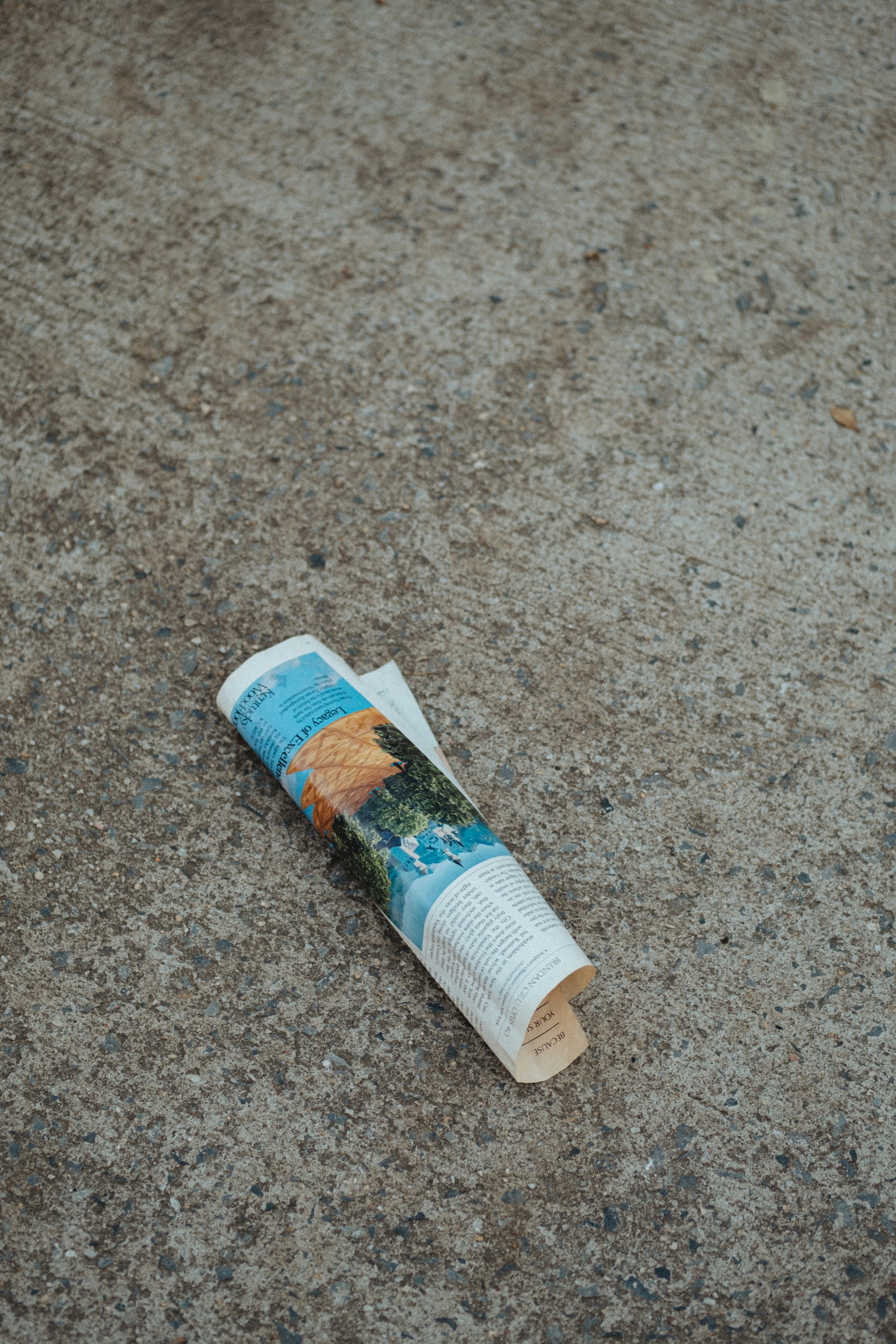 A rolled up newspaper laying on the ground photo – Free Magazine Image ...