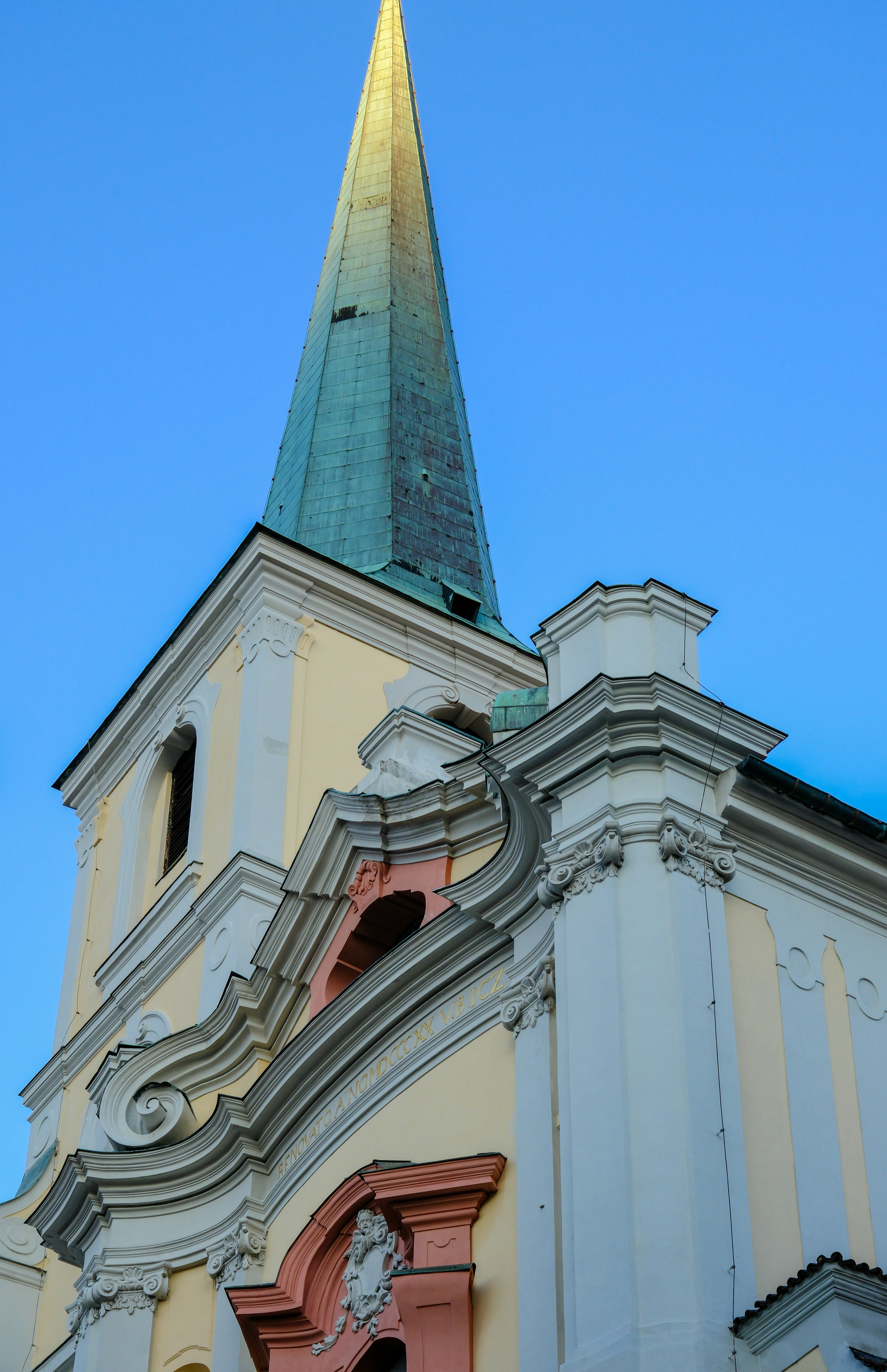 Emerald Spire Rising Over a Pastel Baroque Façade
