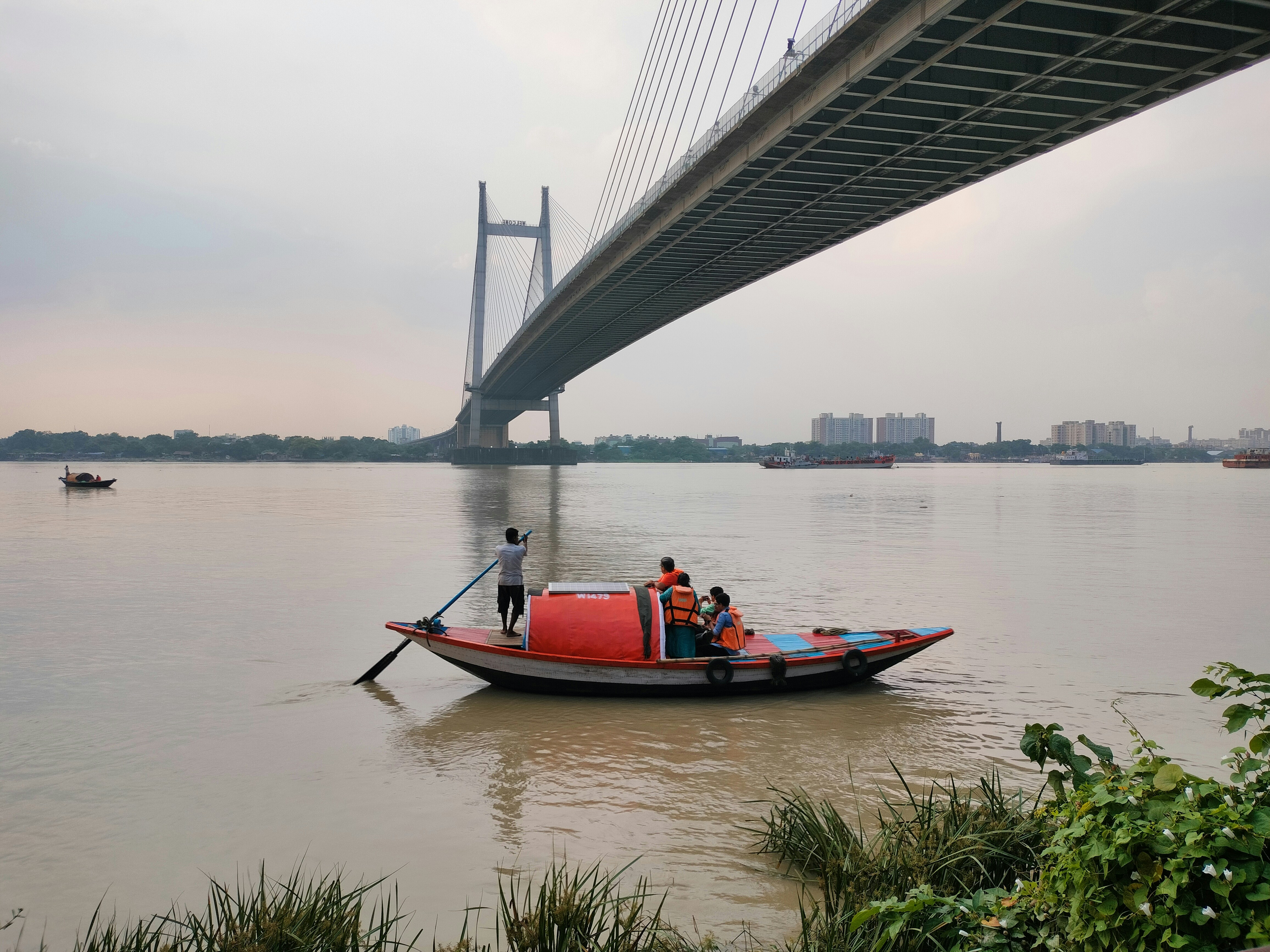 A boat with two people in it floating under a bridge photo – Free ...
