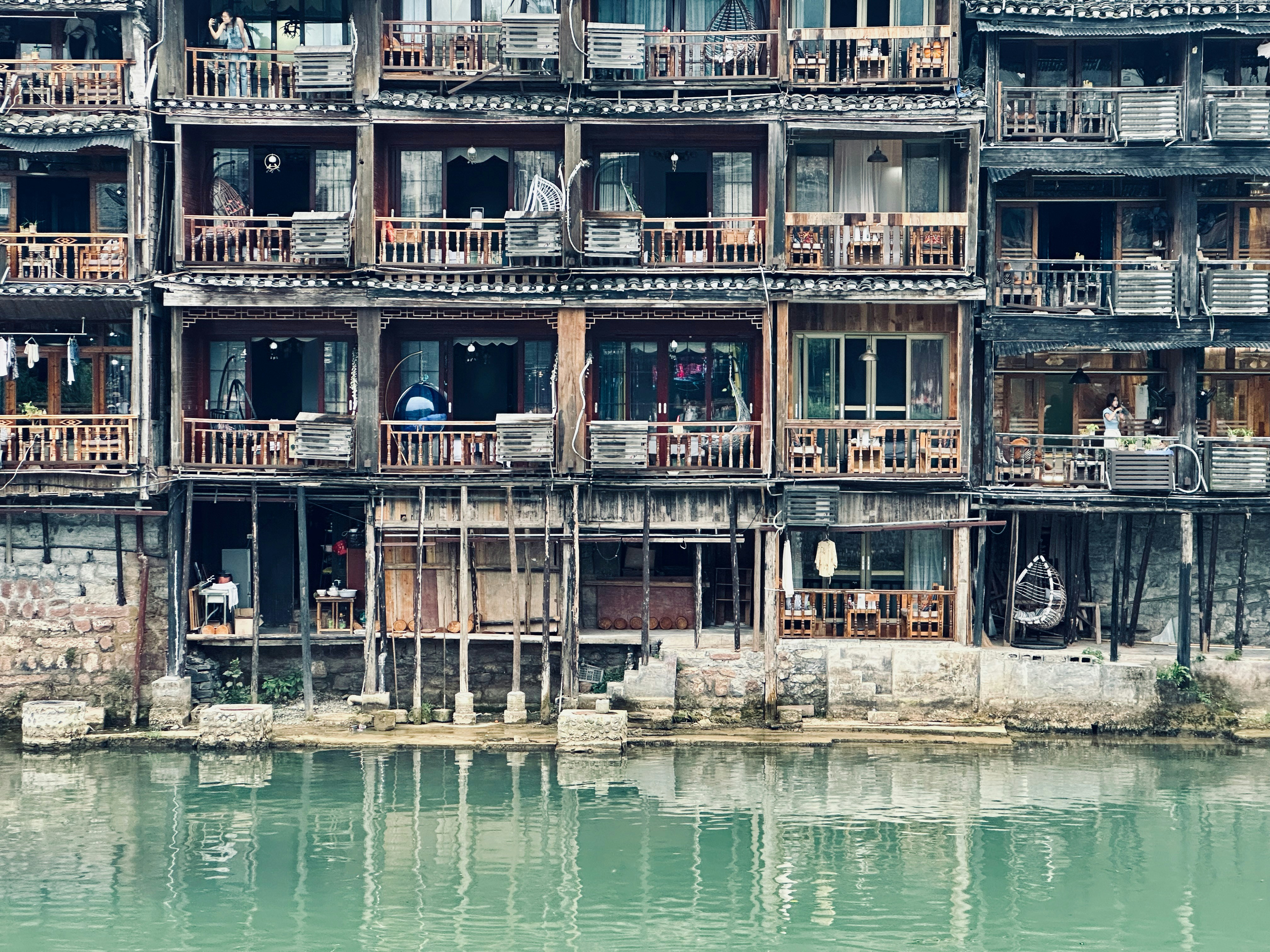 Timber Balcony Grid by the River: Weathered Waterfront Dwellings