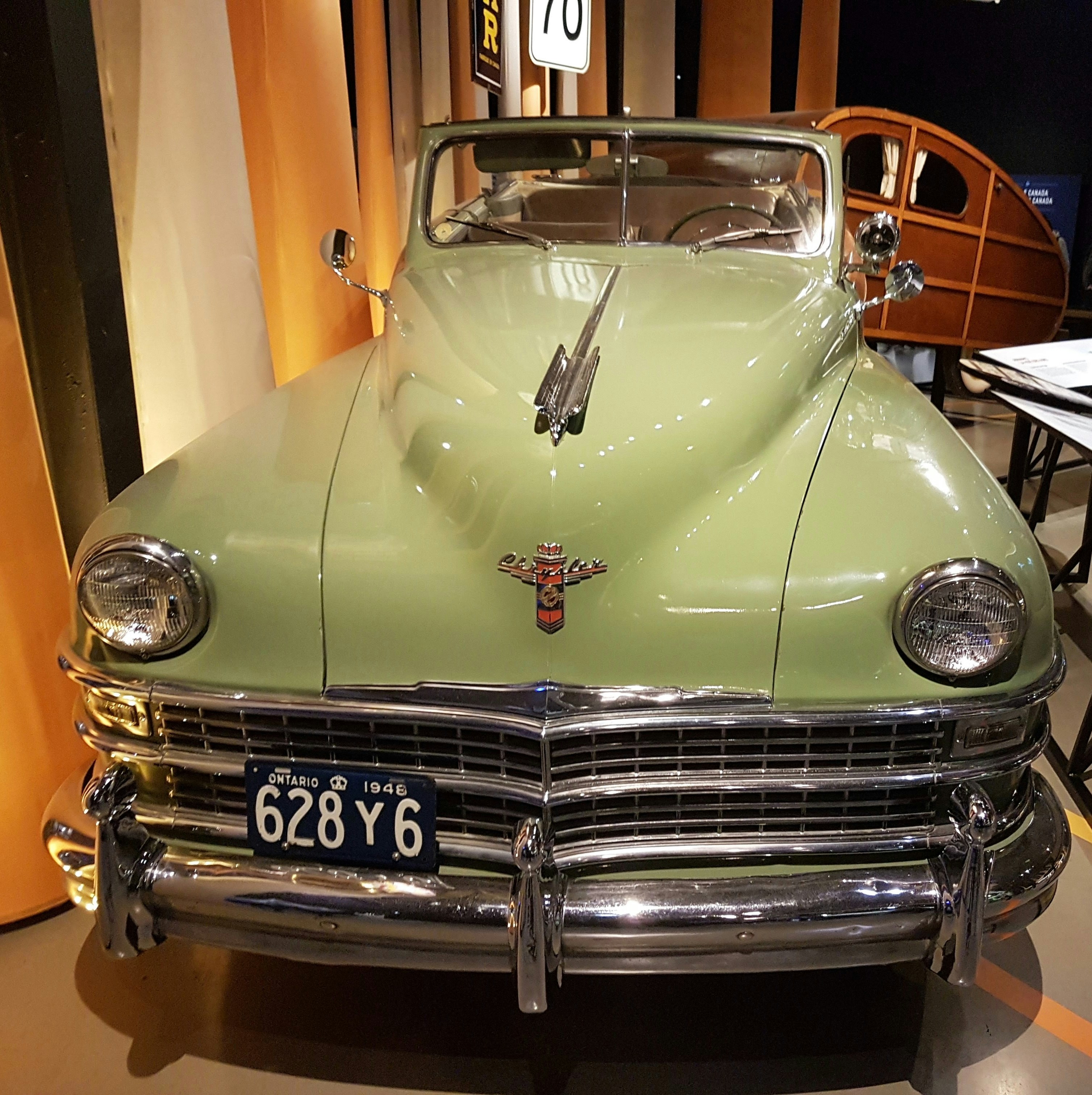 Green Vintage Car from the Front: Chrome Grille and Emblem Spotlight