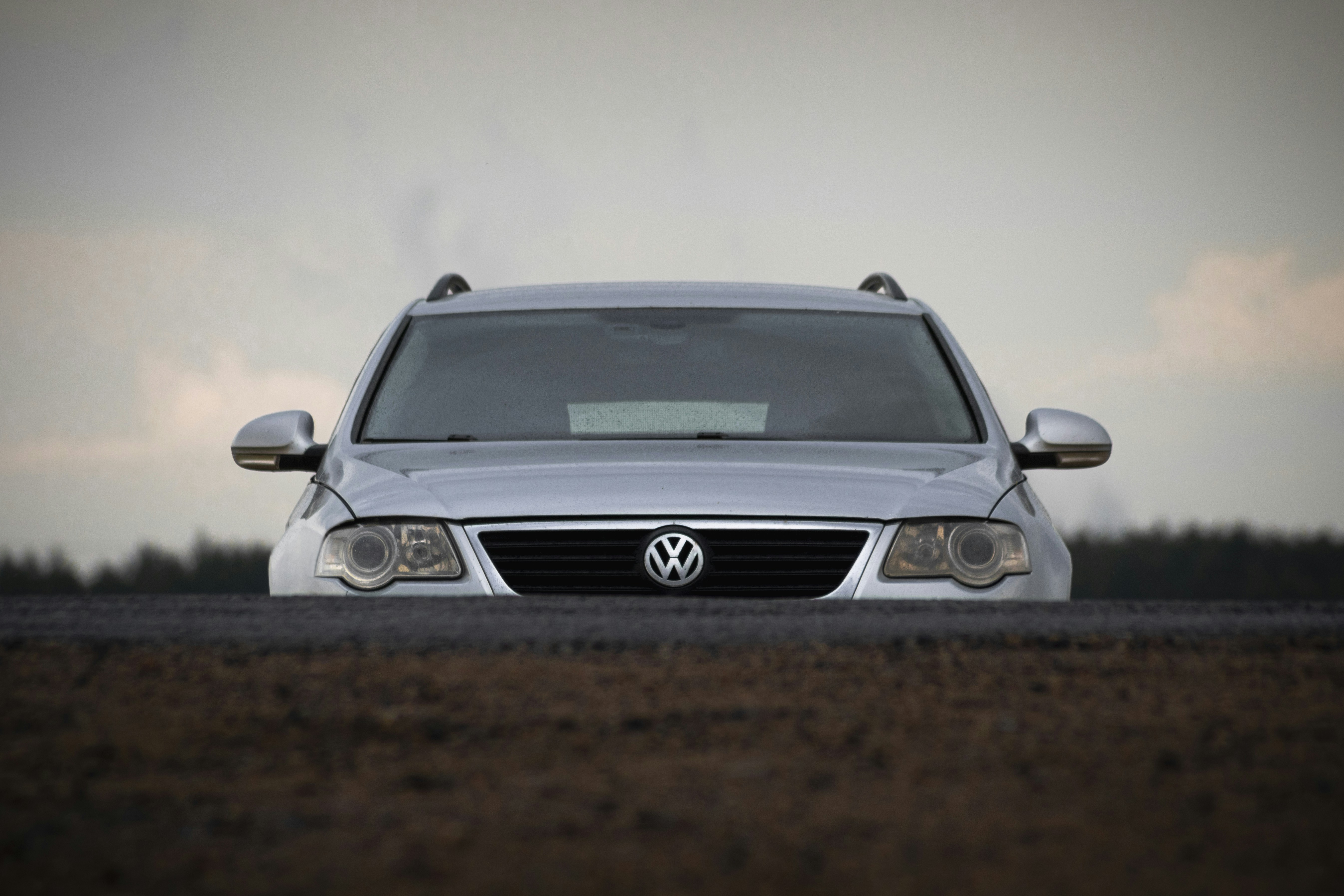 Waterline Reveal: A White VW Sedan Frontally Emerges from Muddy Flood