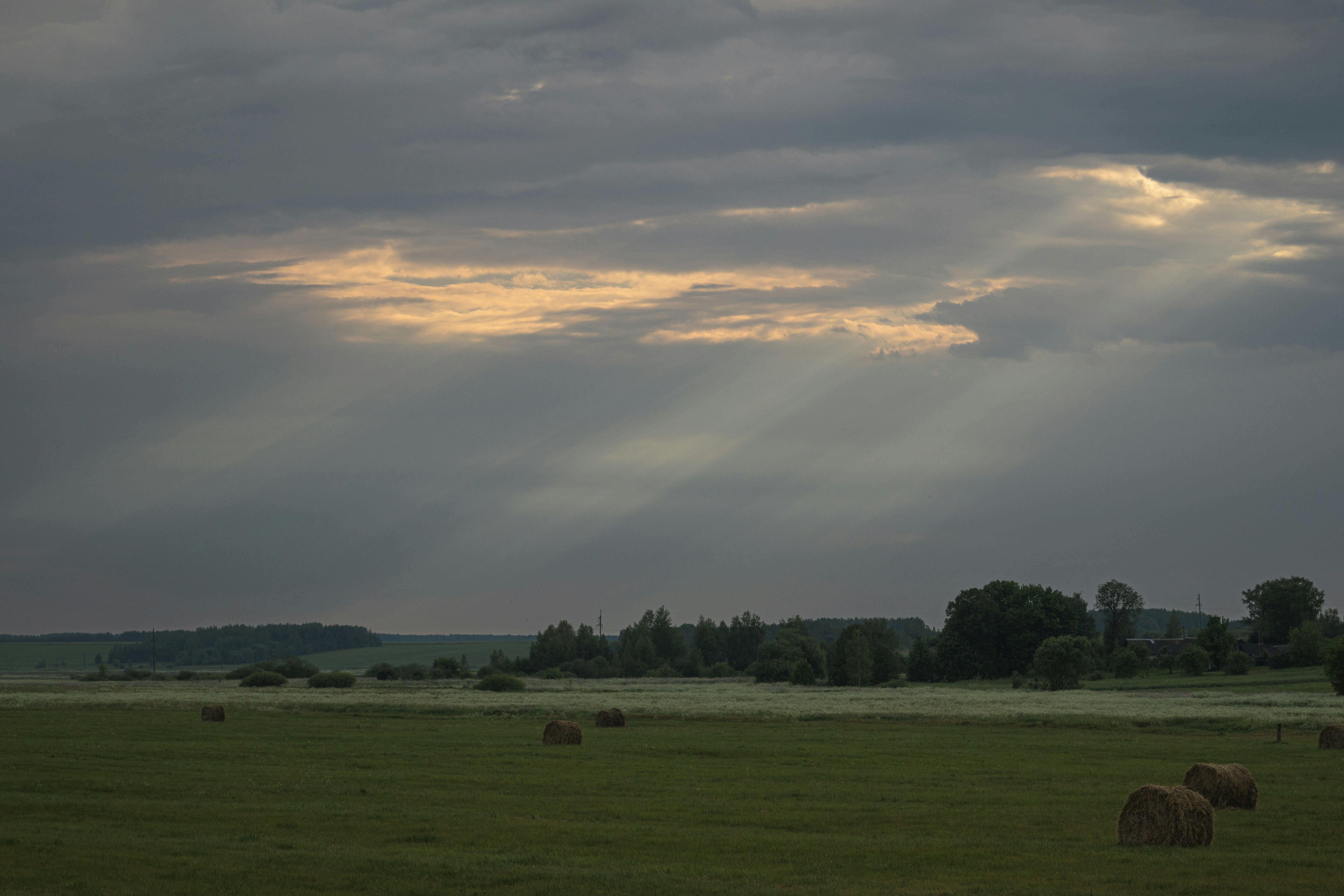 Sunbeams Thread Through a Prairie of Hay Bales