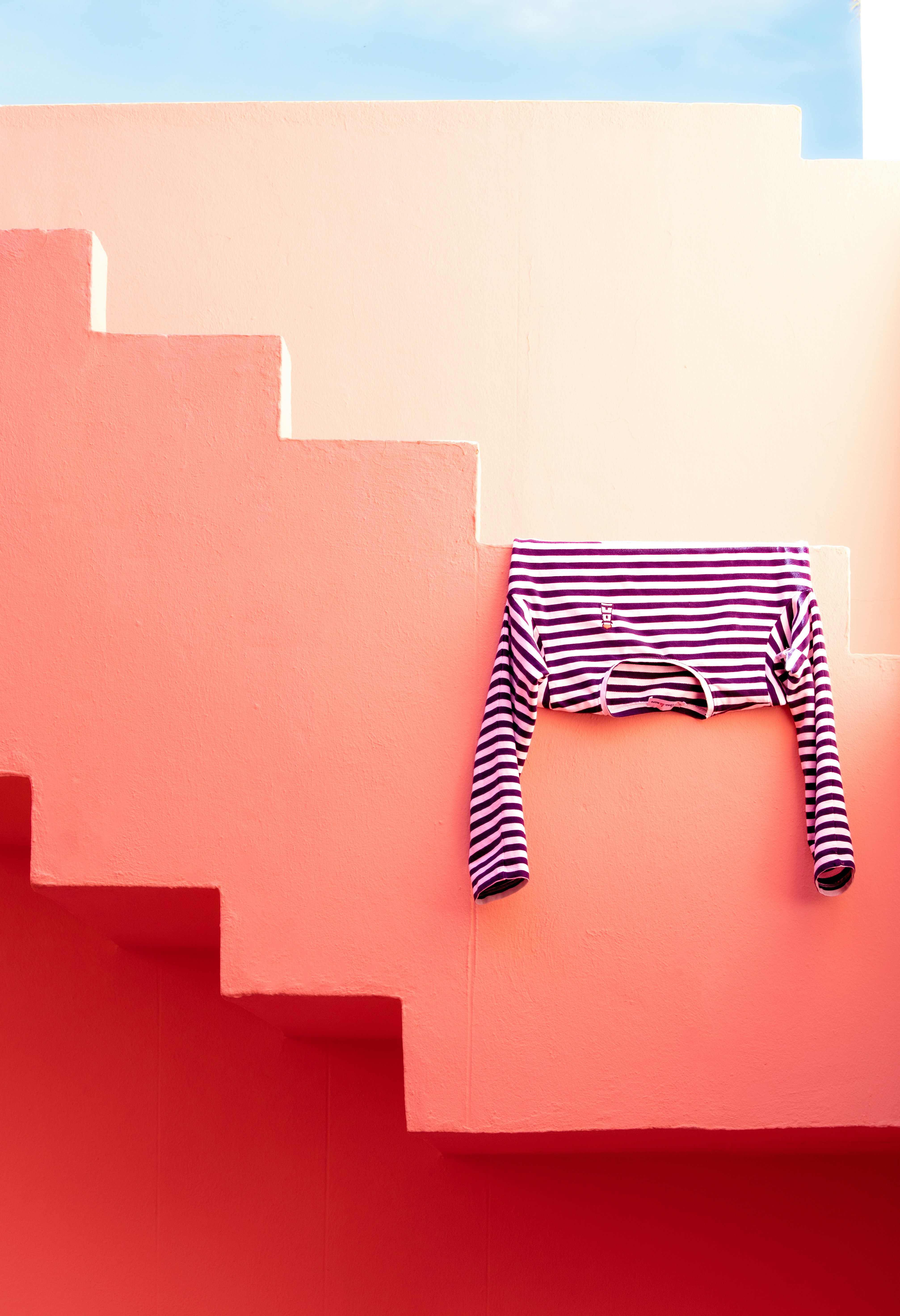 Striped garment on a peach staircase: a color-block moment