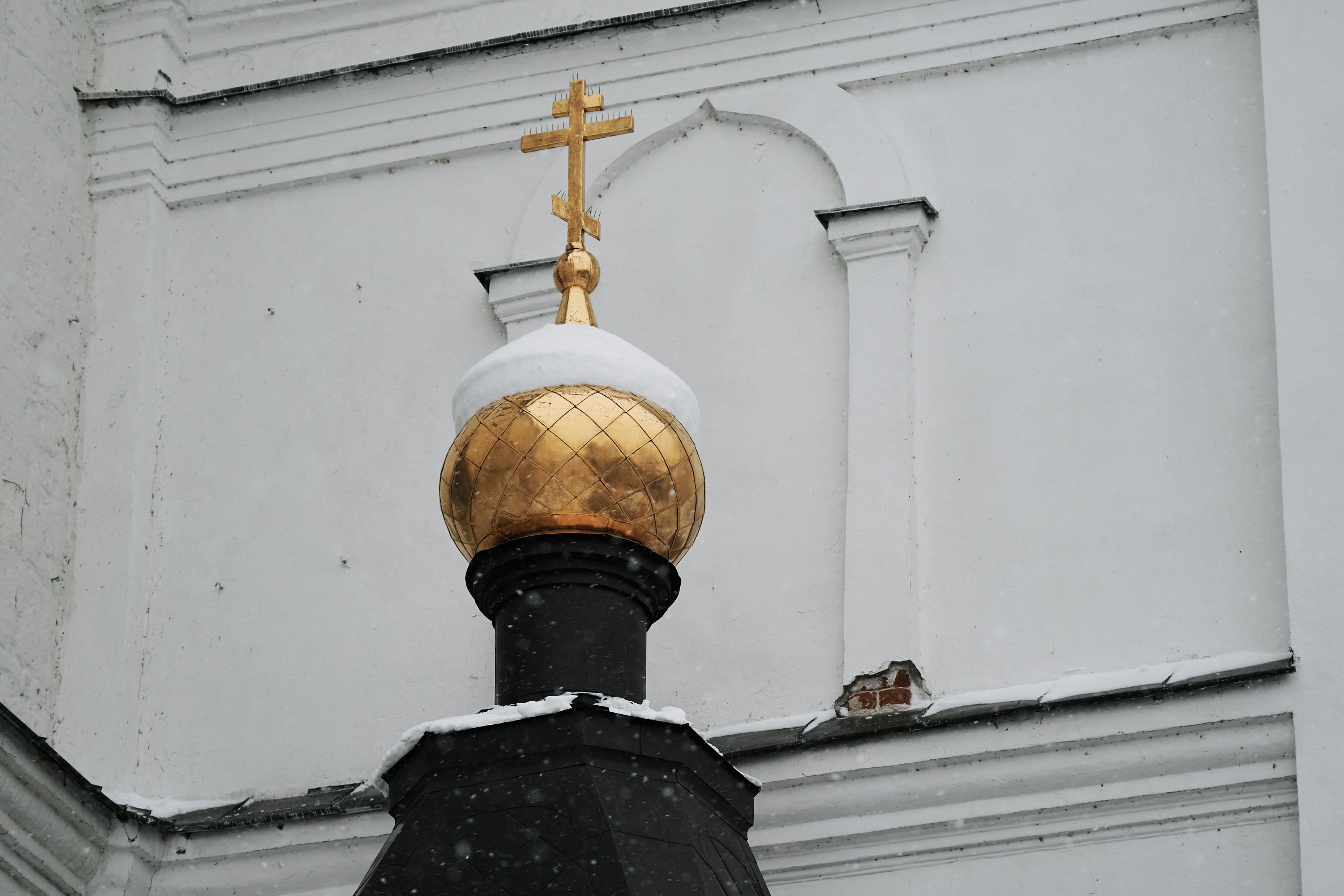 Gilded Onion Dome Rising Against Snowy White Facade